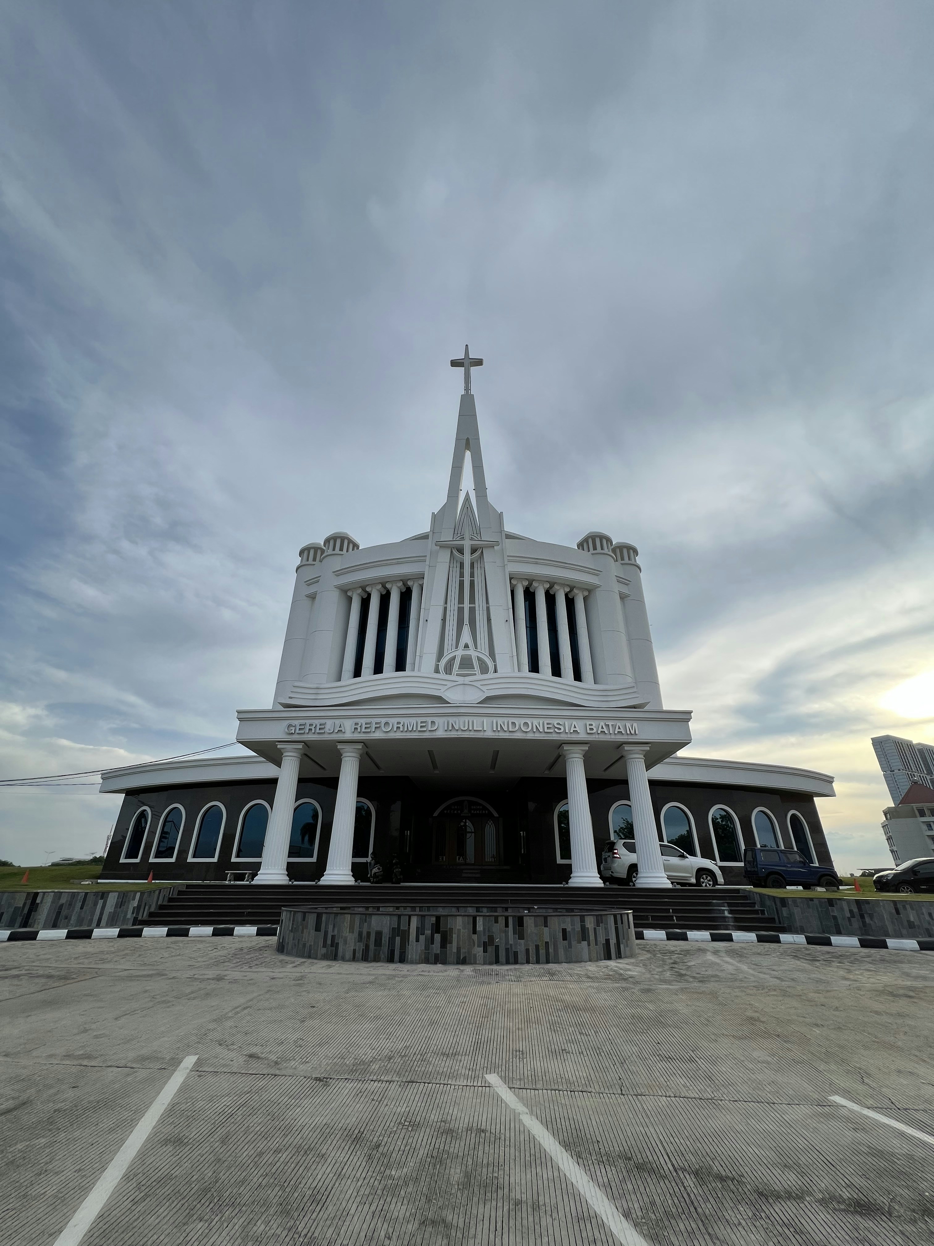 Cross-Topped White Chapel Rising Over a Circular Forecourt