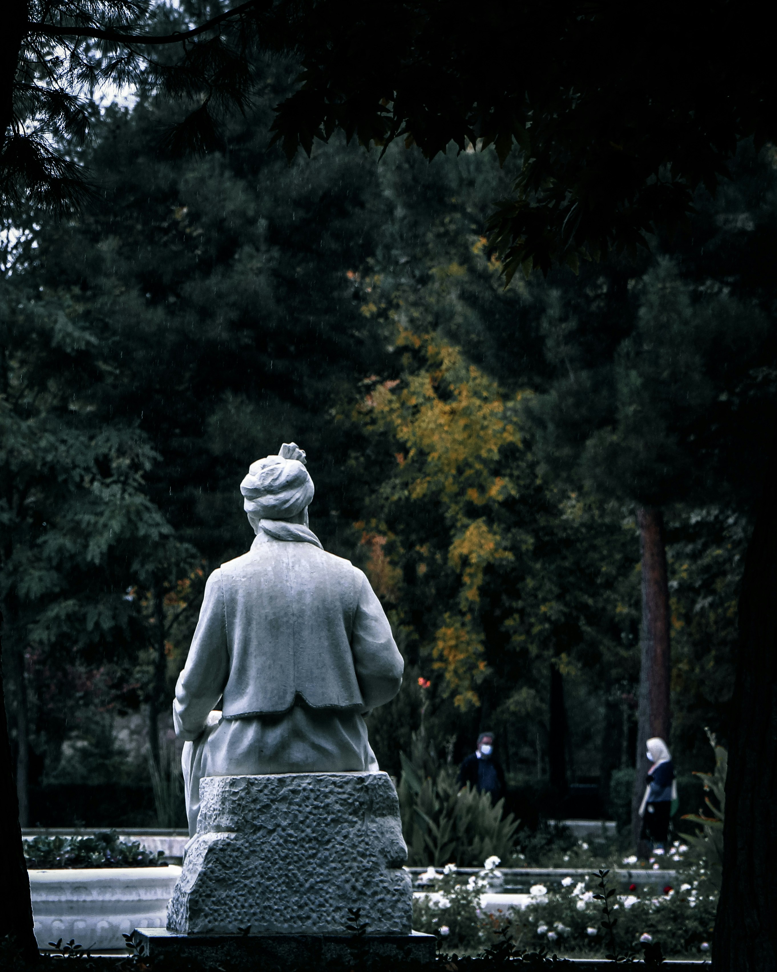 The Quiet Sentinel: A Backturned Statue in Dusk's Garden