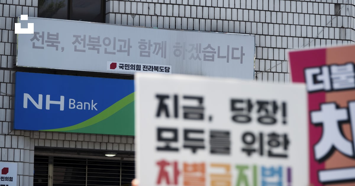 건물 앞에서 표지판을 들고 있는 한 무리의 사람들 사진 Unsplash의 무료 대한민국 이미지
