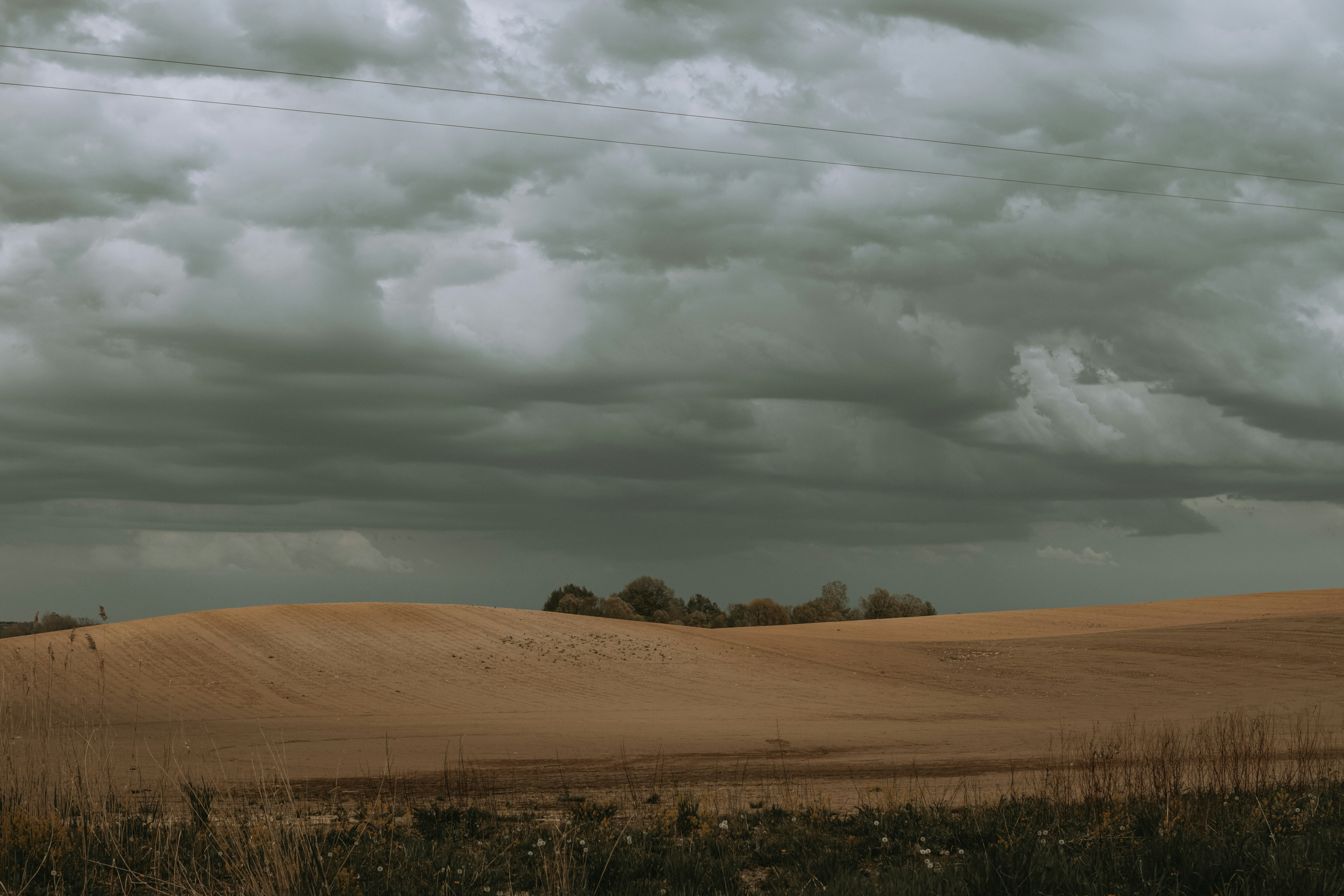 Foto zum Thema Ein großes Feld mit einem Himmel voller Wolken ...