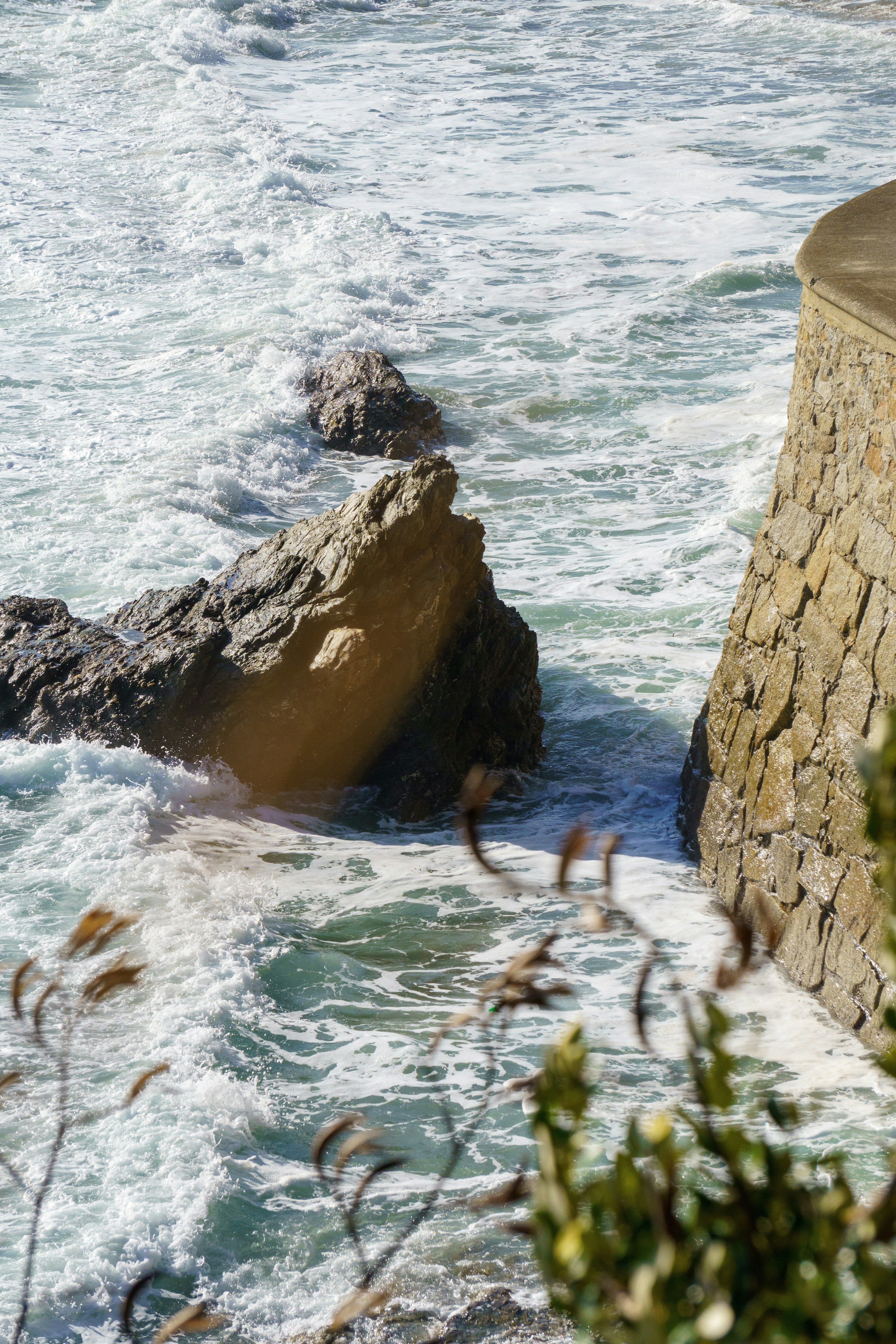 A large rock sticking out of the ocean photo – Free Sea Image on Unsplash