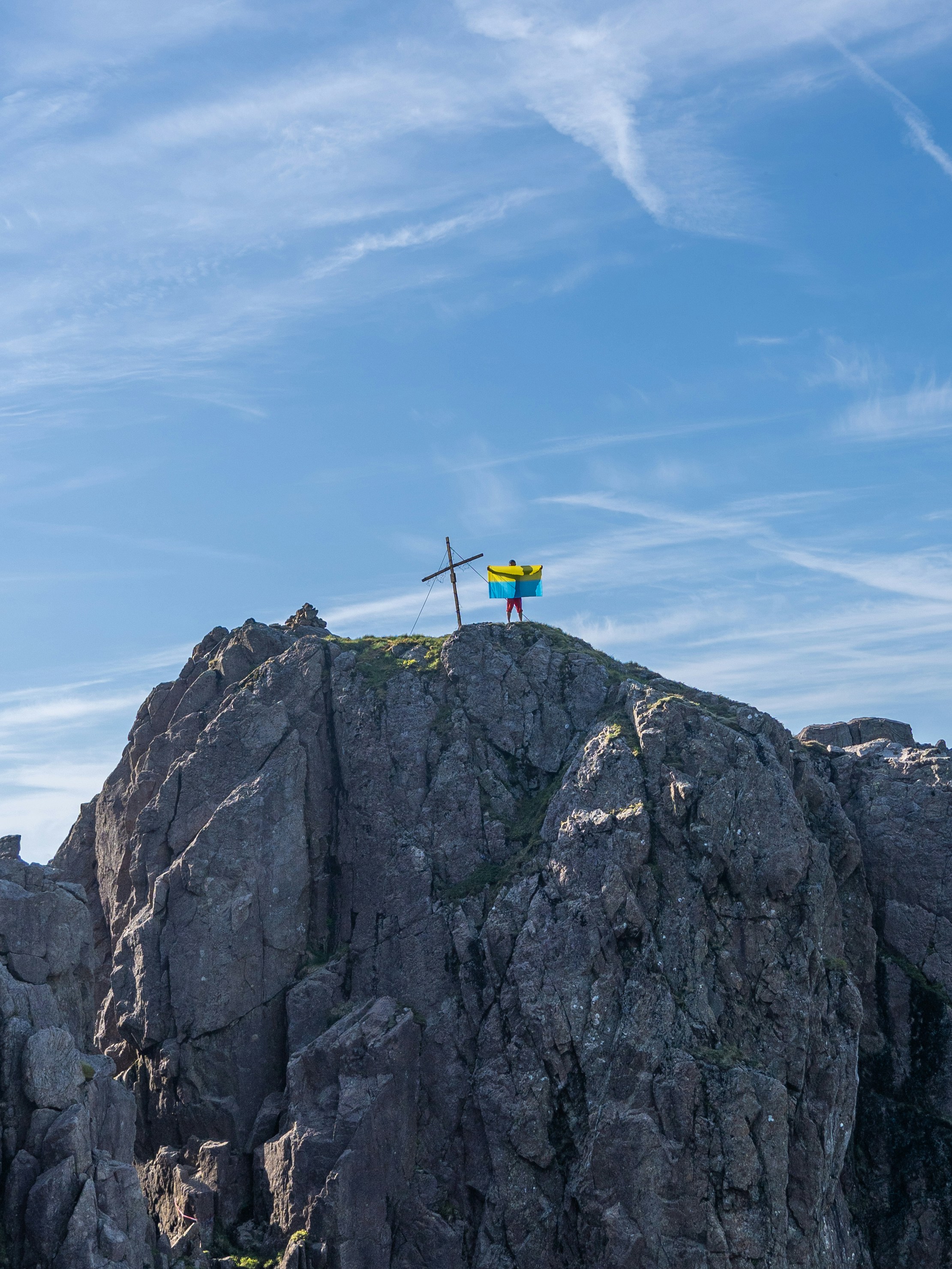 Foto Una persona parada en la cima de una montaña con una cruz – Imagen ...