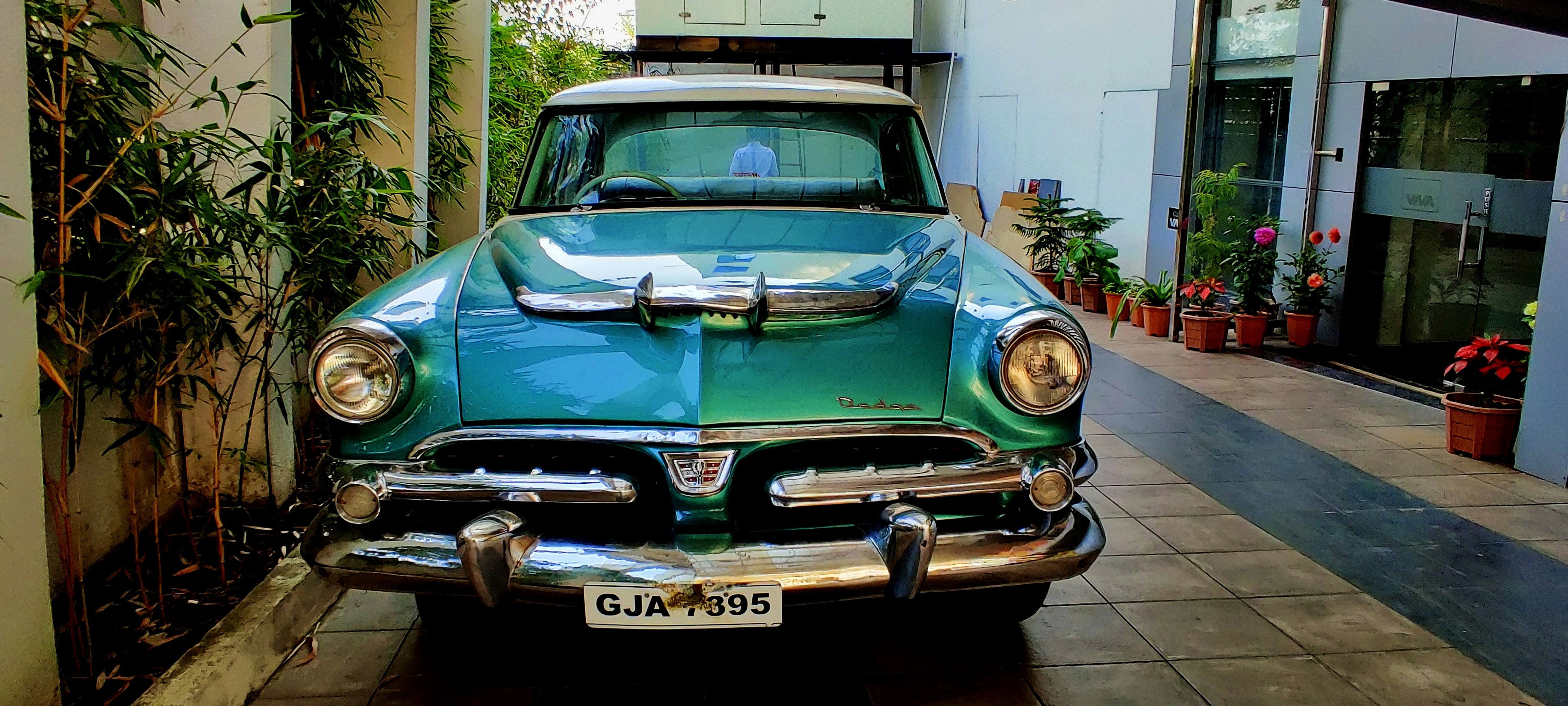 Turquoise Classic: A Vintage Chevrolet Guarded by Modern Courtyard