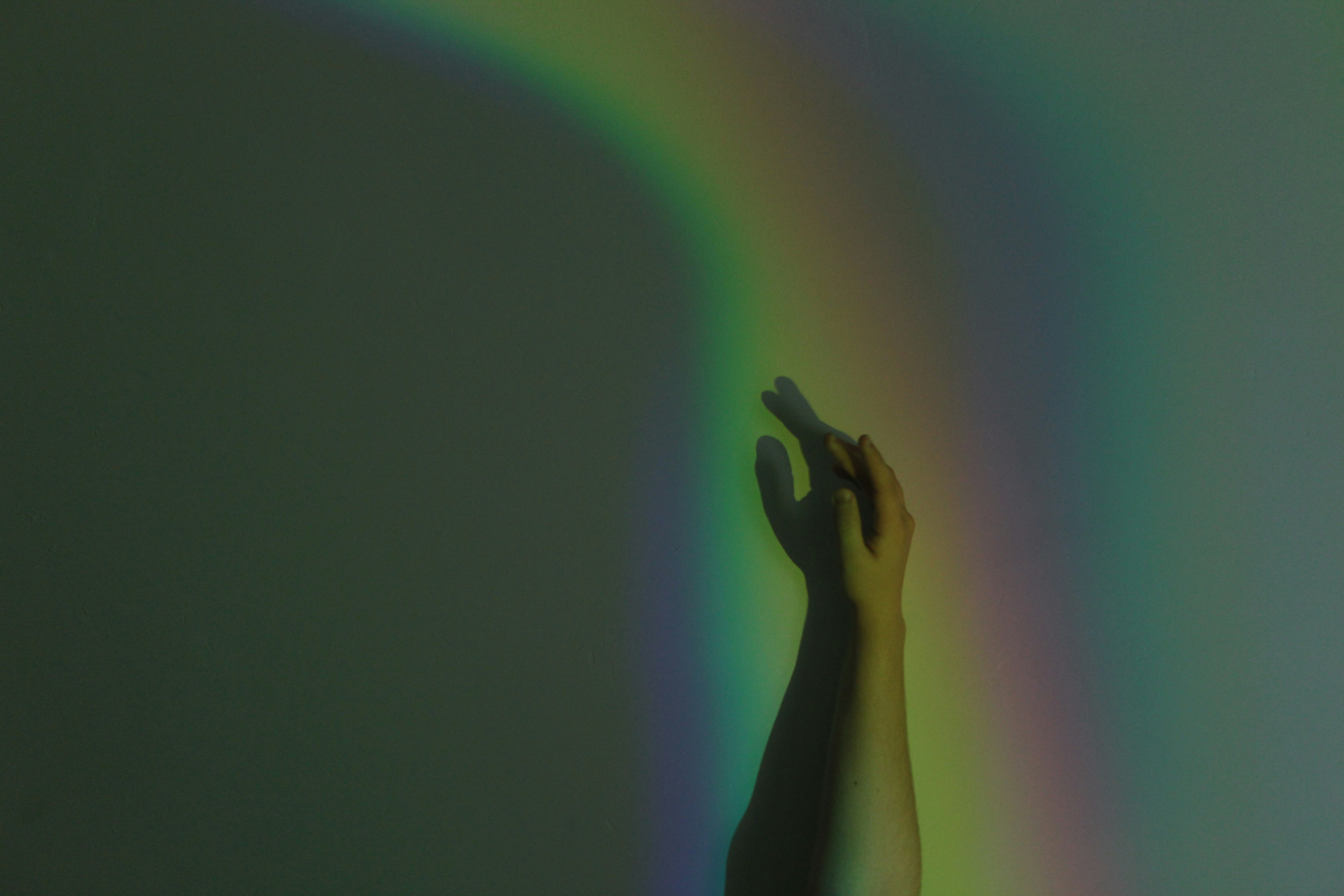 A person's hand reaching up to a rainbow photo – Free Person Image on ...