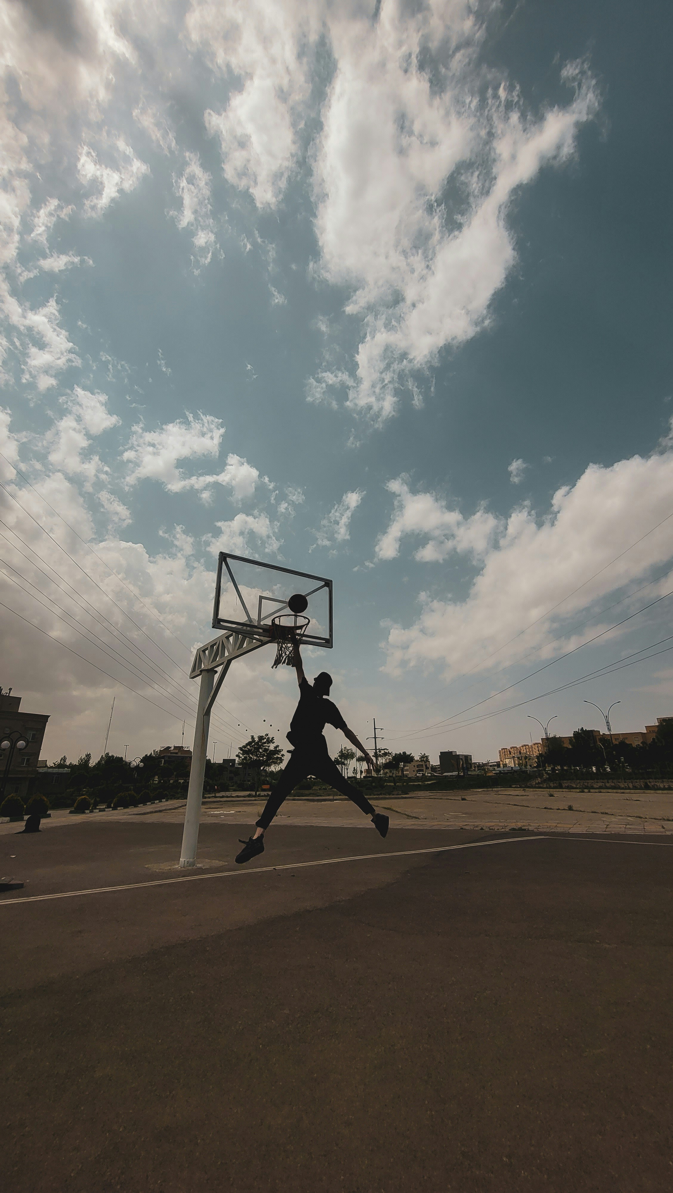 A person jumping up into the air to dunk a basketball photo – Free ...