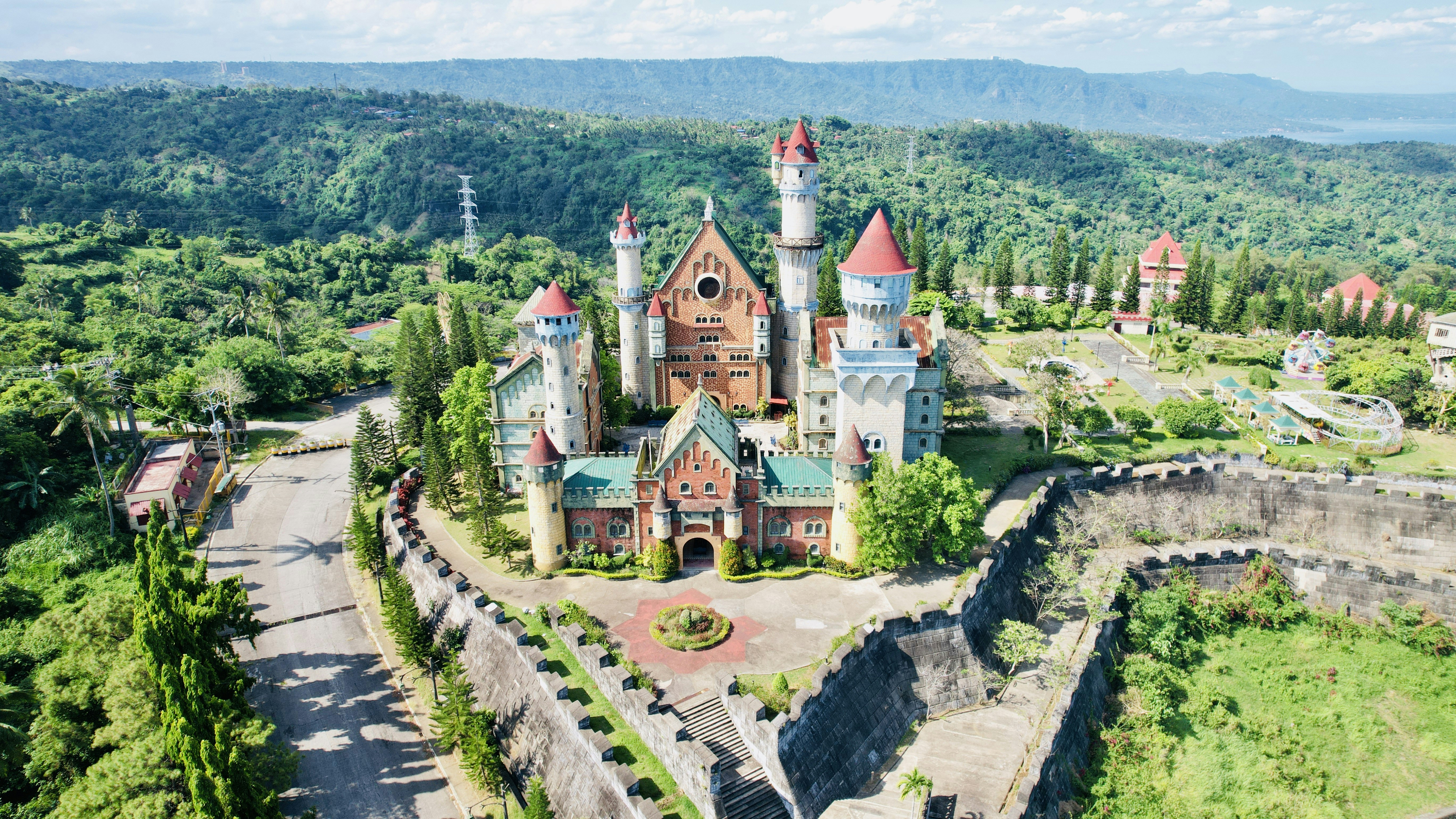 An aerial view of a castle in the middle of a forest photo – Free ...