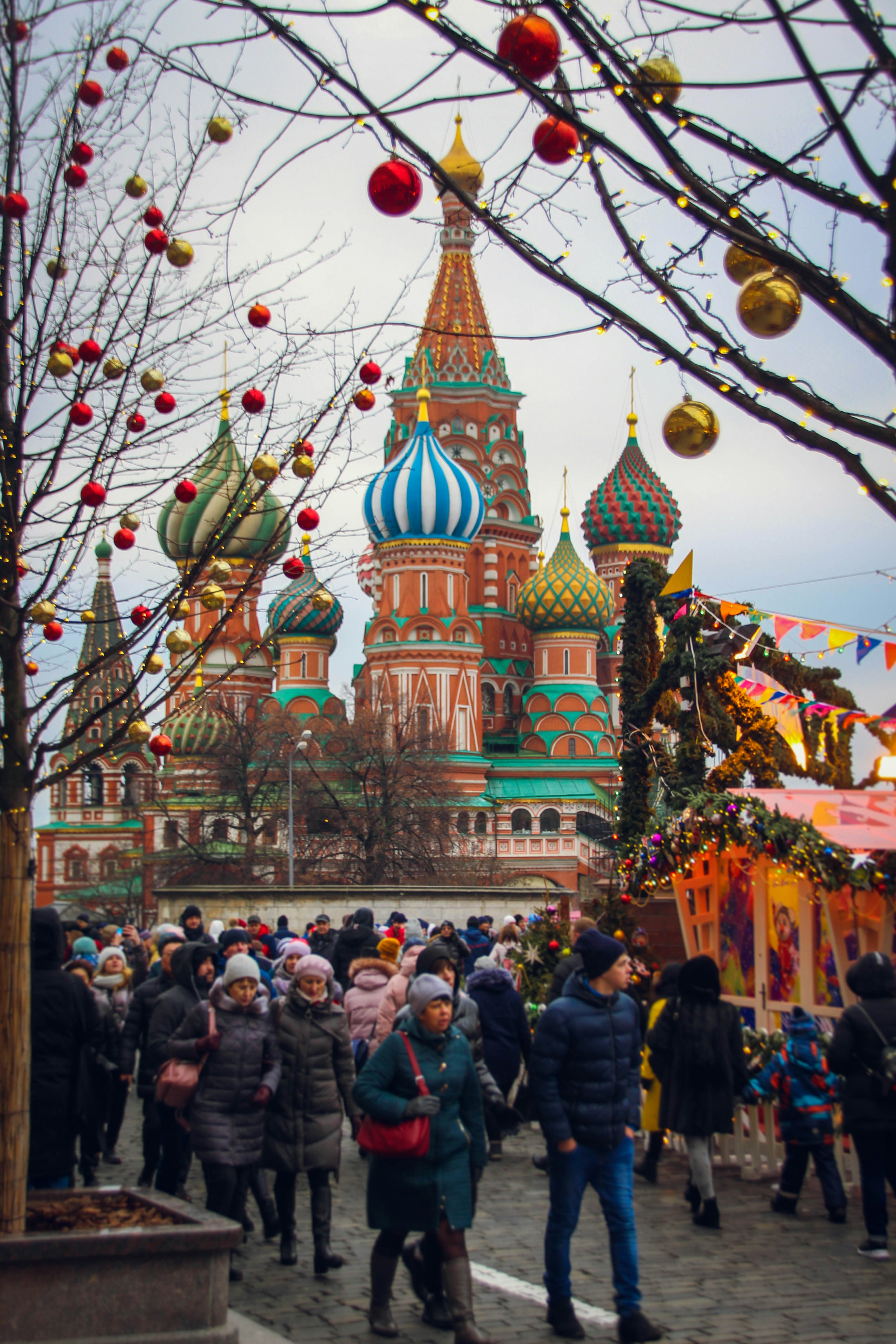 A crowd of people walking down a street next to a tall building photo ...