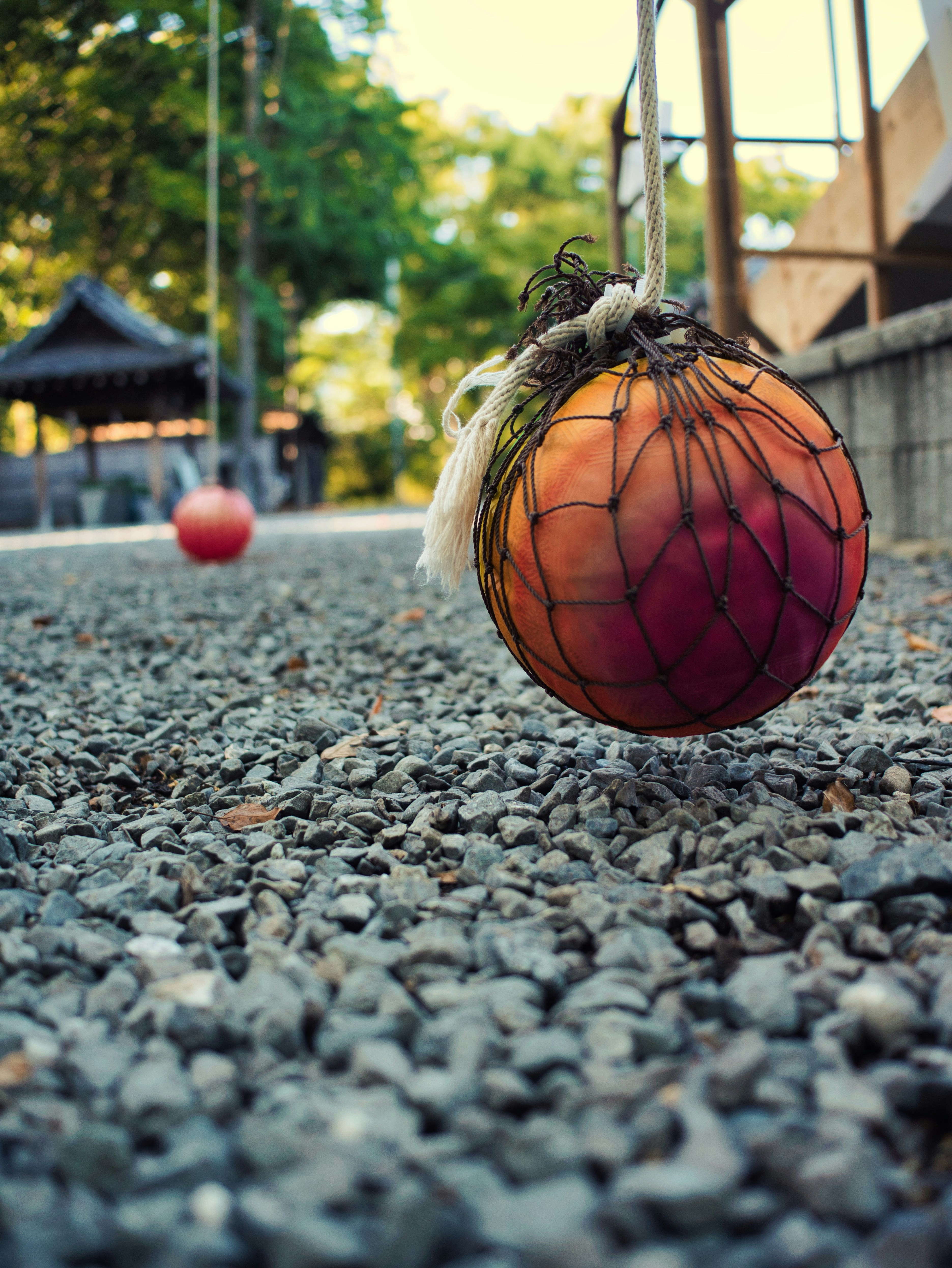 A red ball hanging from a rope on the ground photo – Free Sphere Image ...