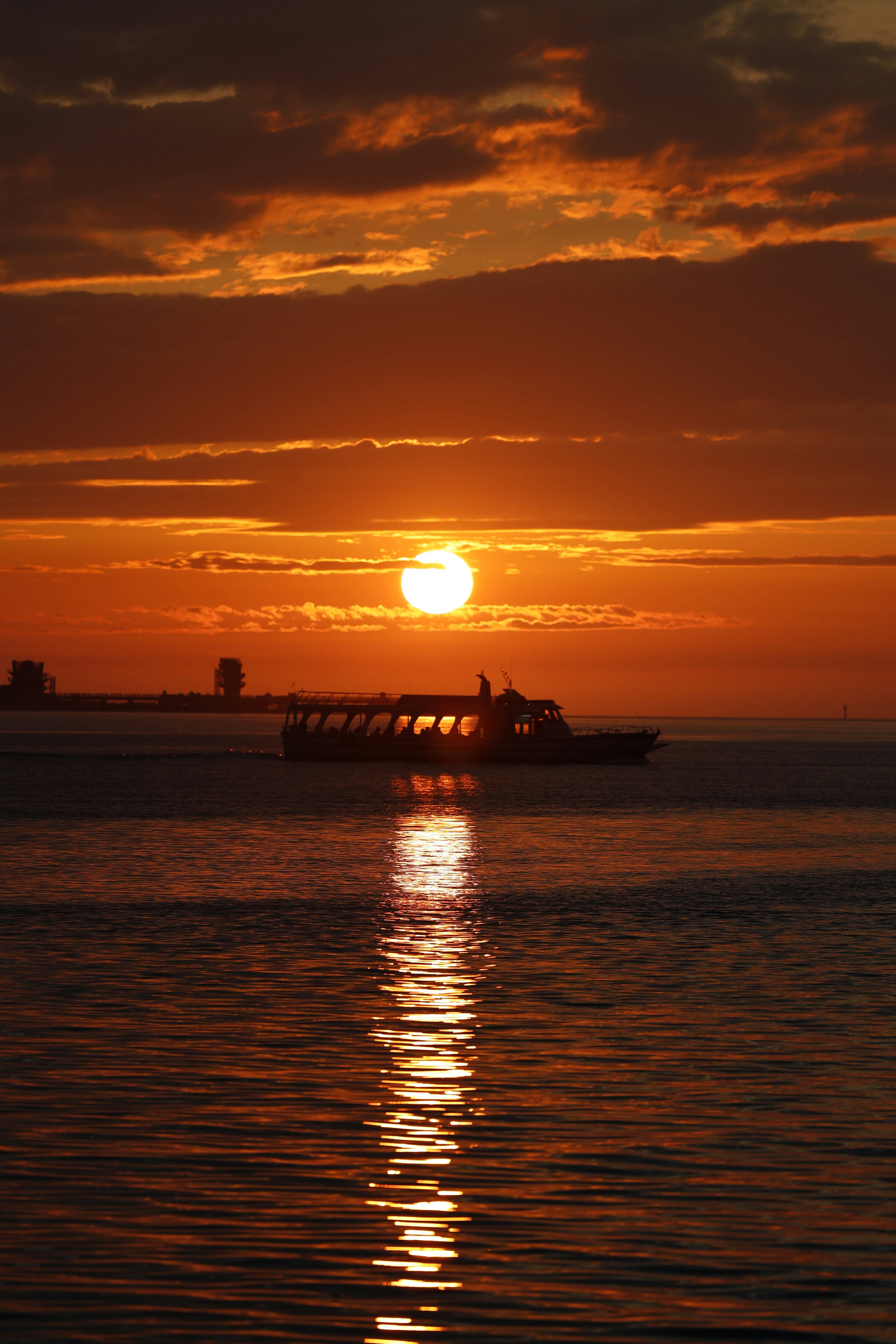 Golden Hour Vessel: Silhouette on a Quiet Sunset Sea