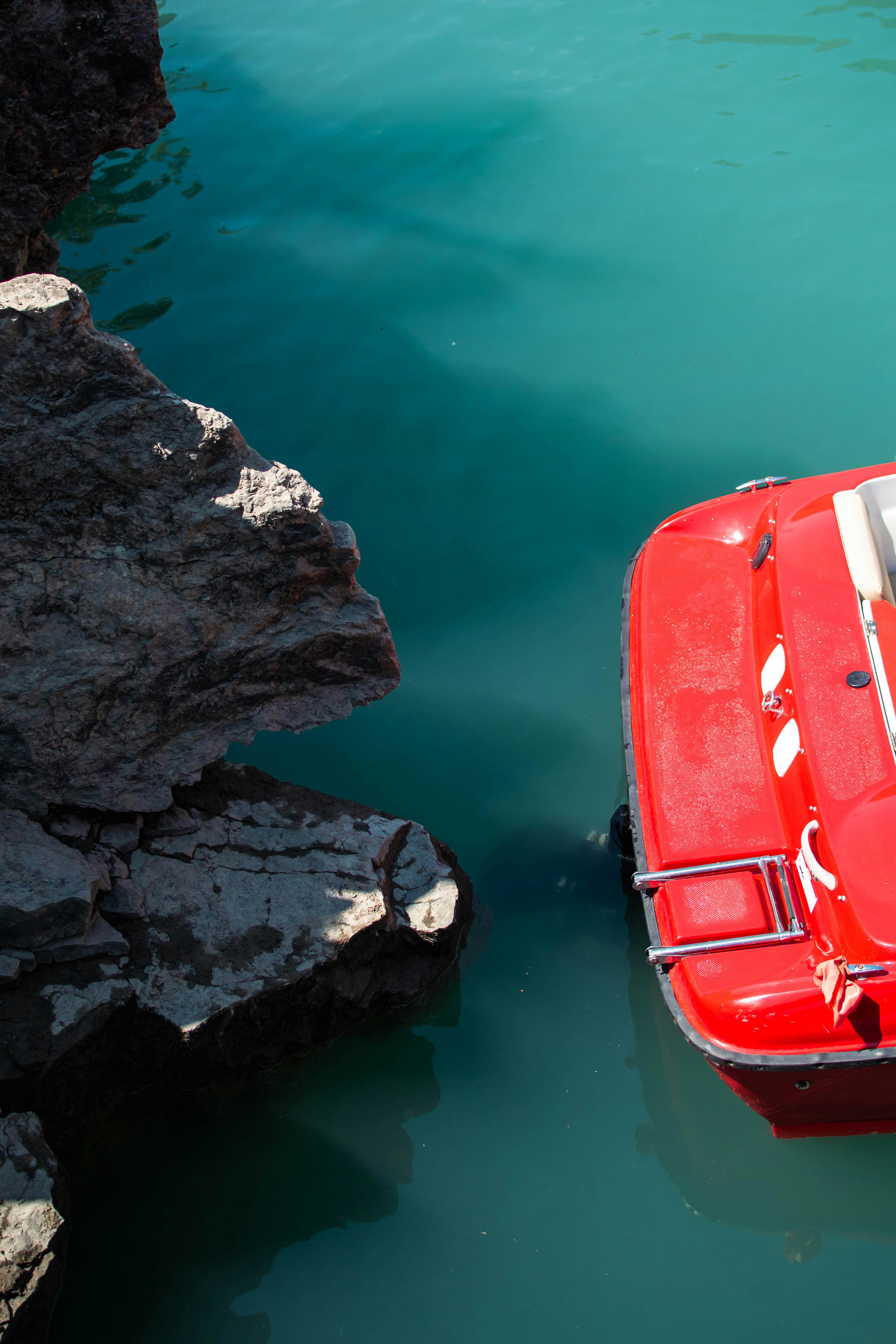 A small red boat in a body of water photo – Free Dagestan Image on Unsplash