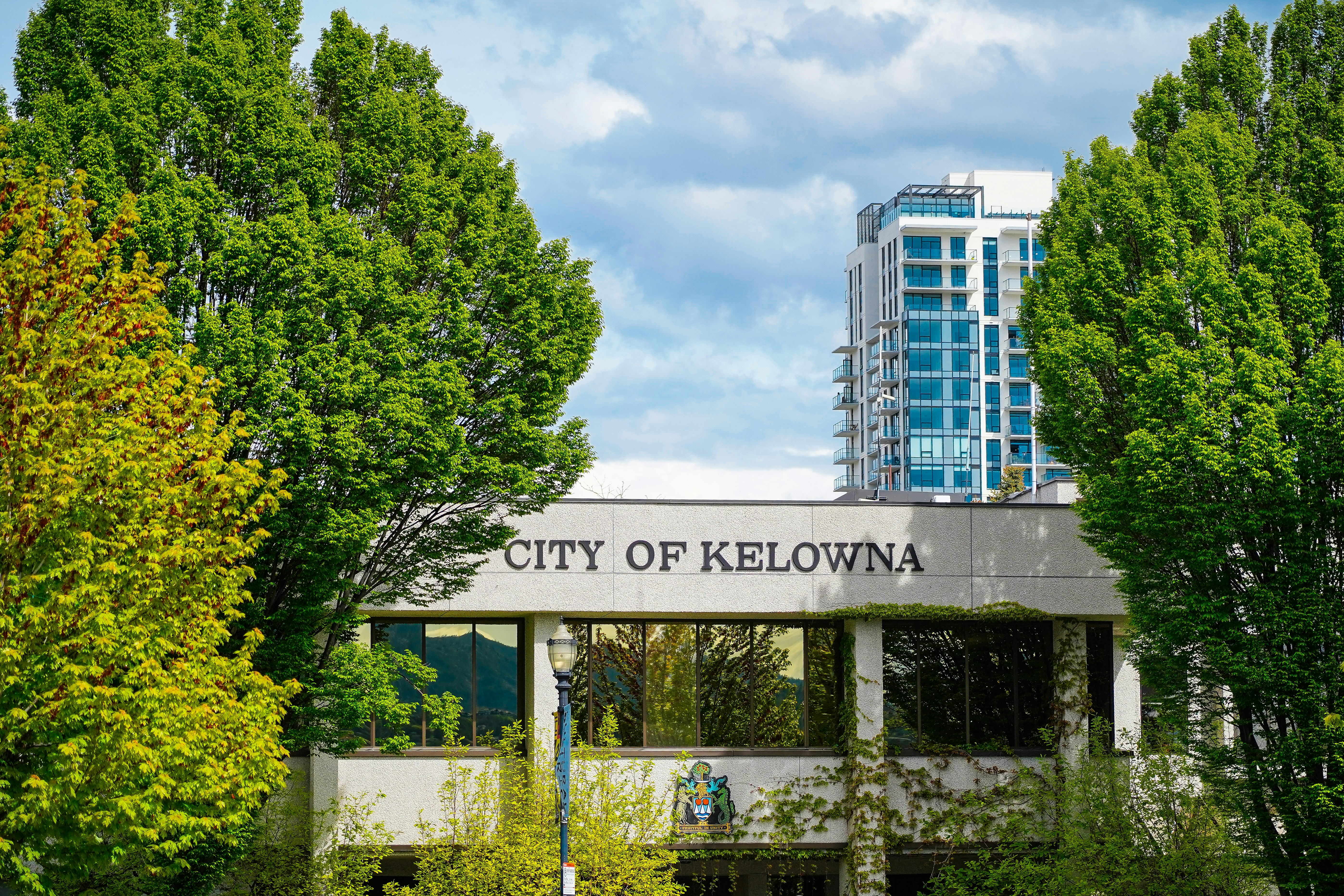 The city of kelowa is surrounded by trees photo – Free City hall Image ...