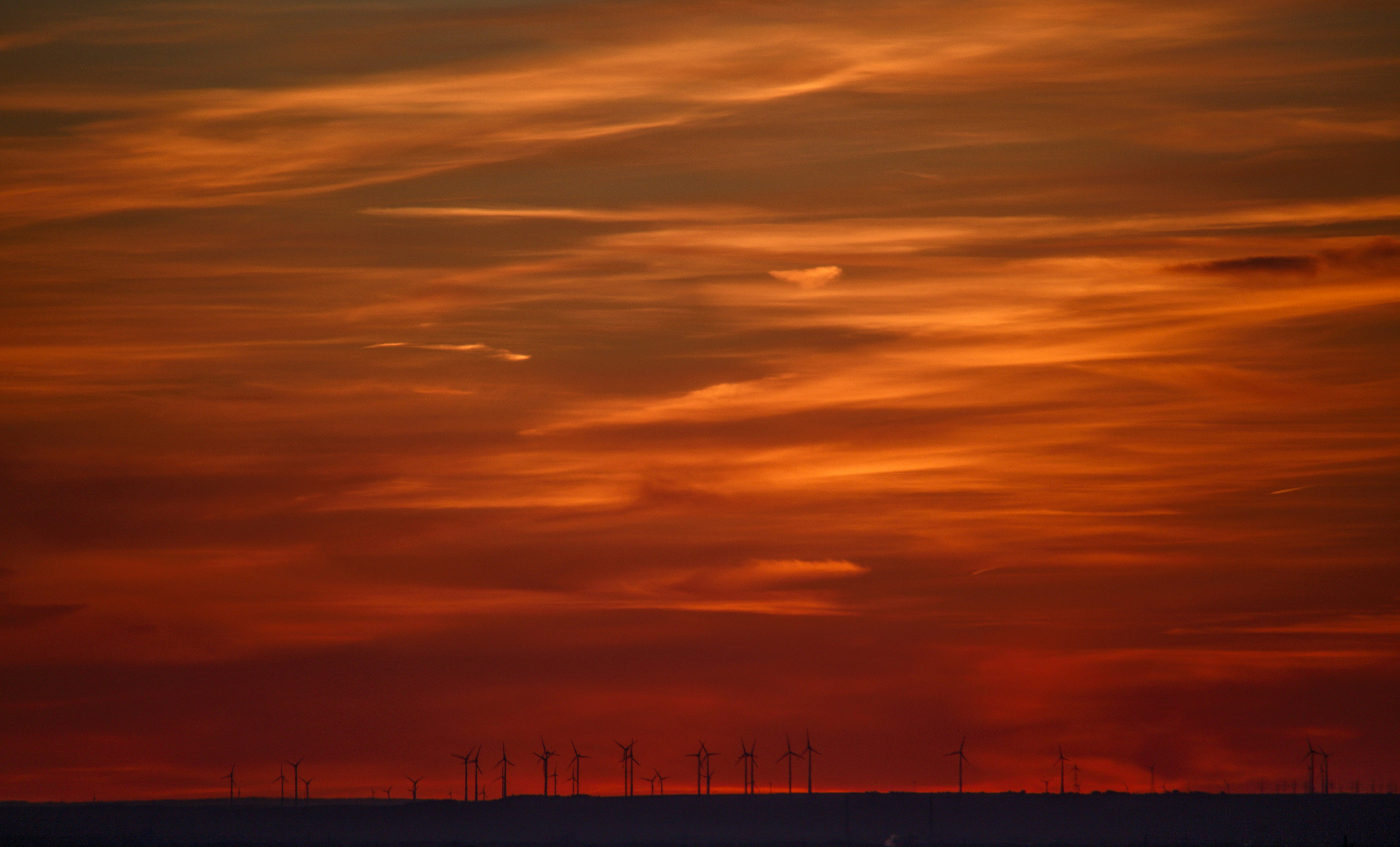 A red sky with clouds and wind mills in the distance photo – Free Weinheim Image on Unsplash
