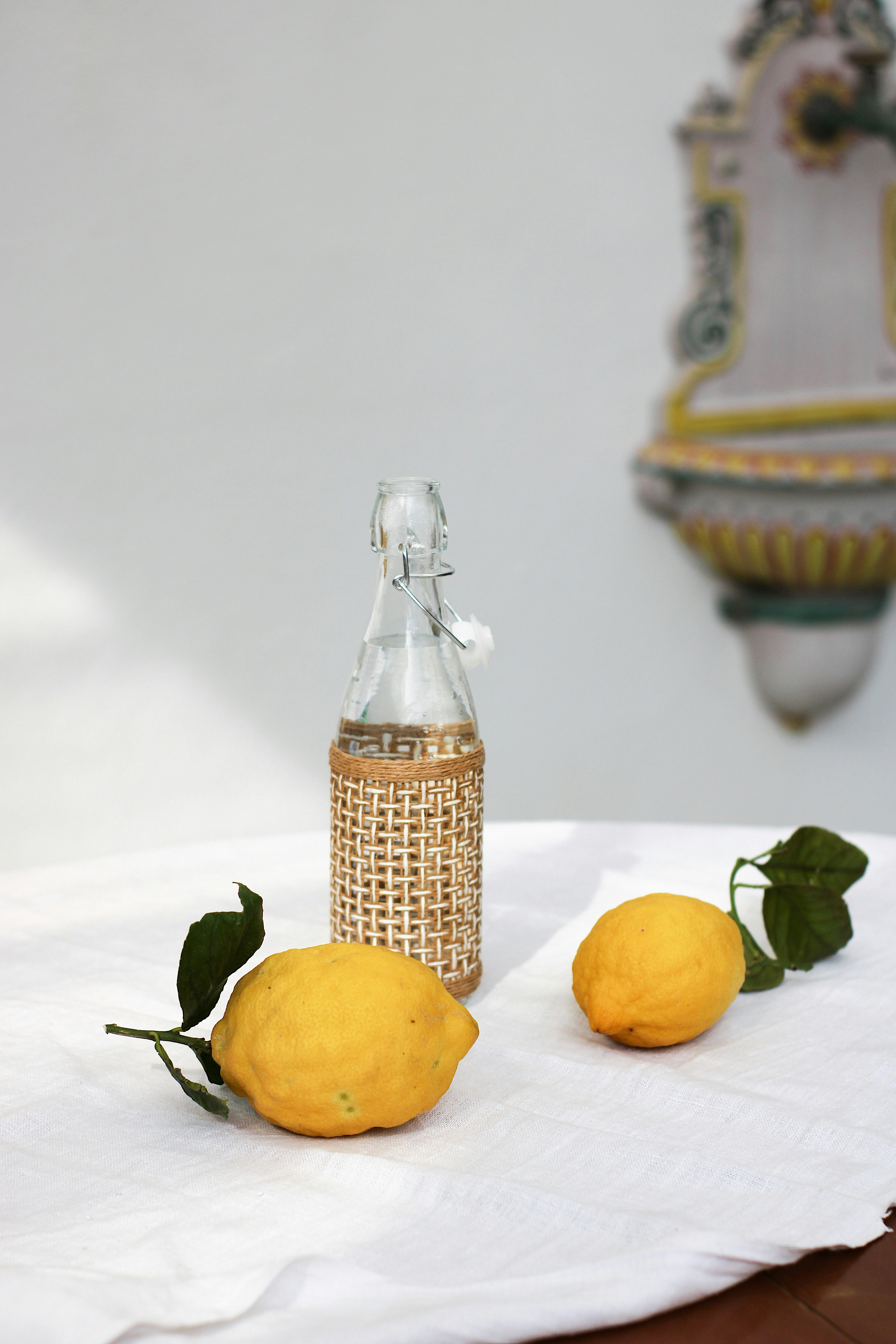 two lemons and a glass bottle on a table