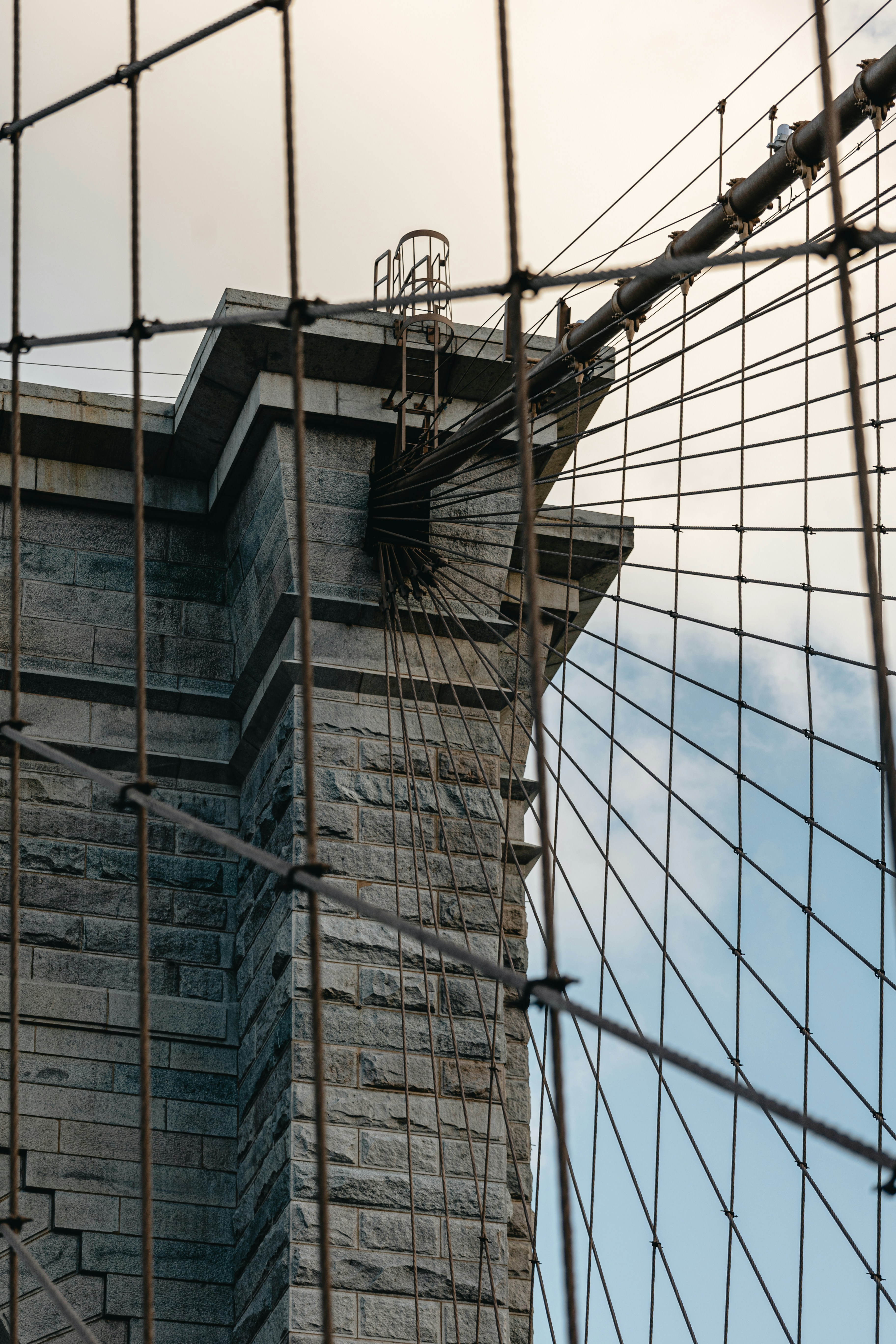 a clock on the side of a building behind a wire fence