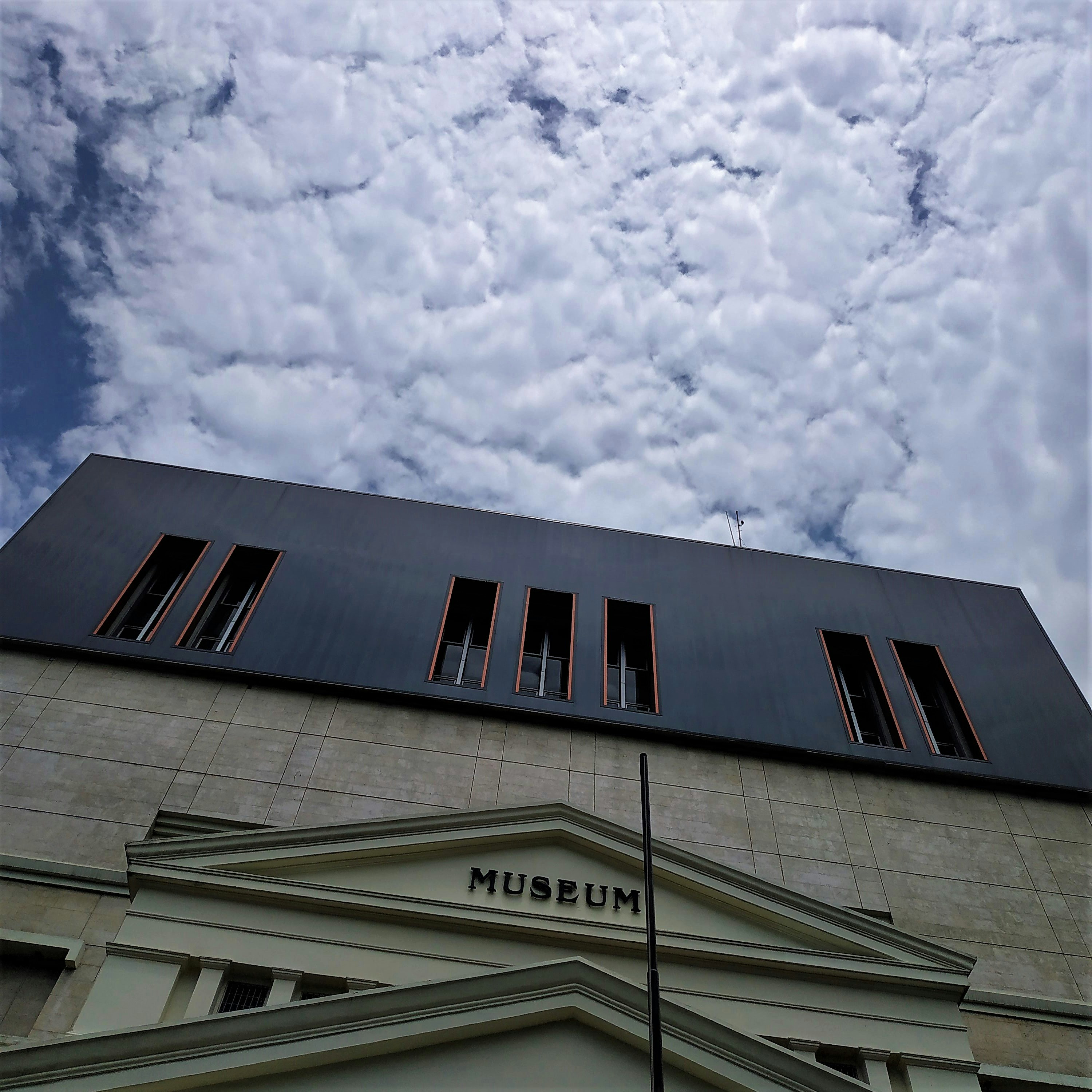 a tall building with windows and a sky background