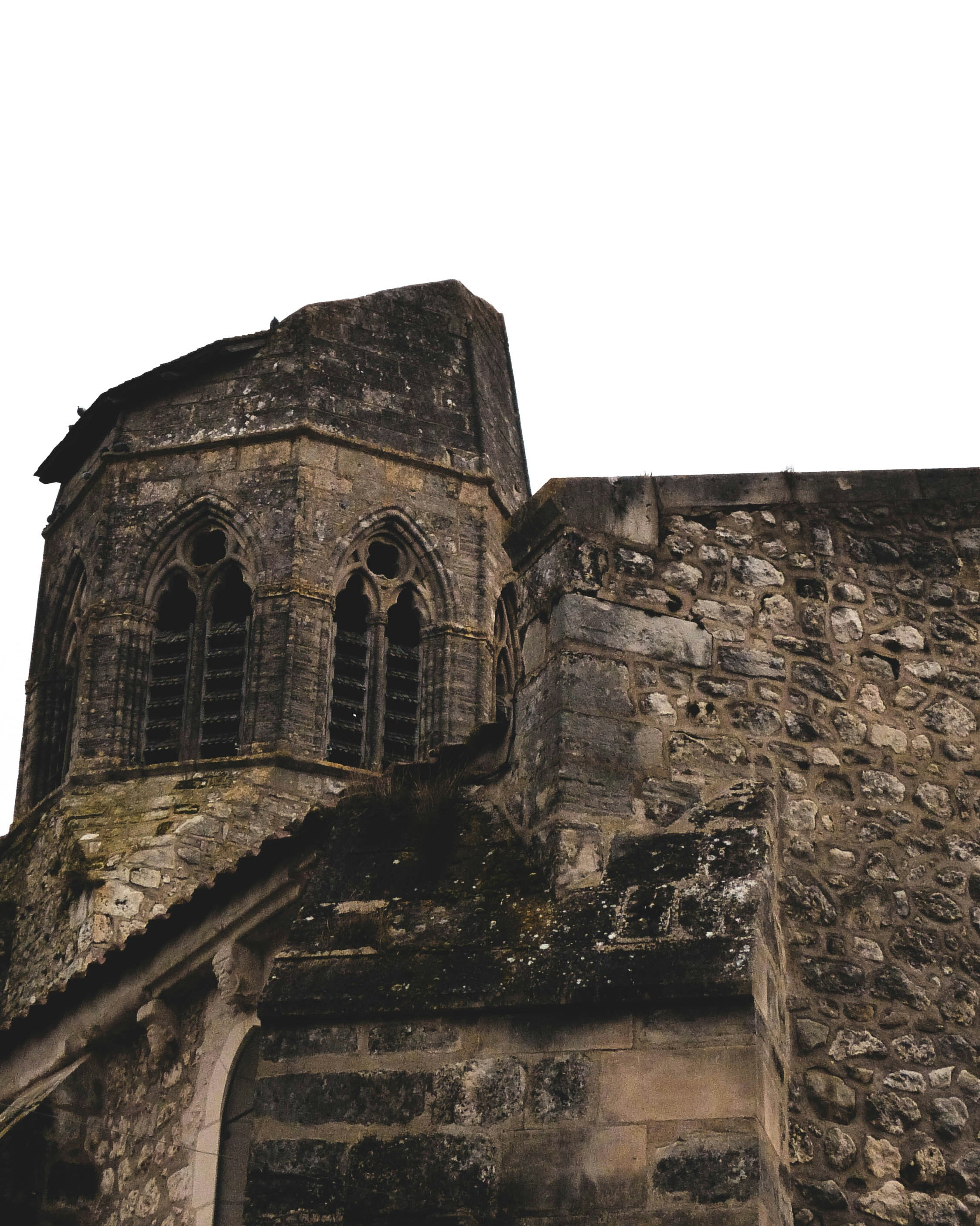 Weathered Gothic Turret: Arched Windows in Timeworn Stone