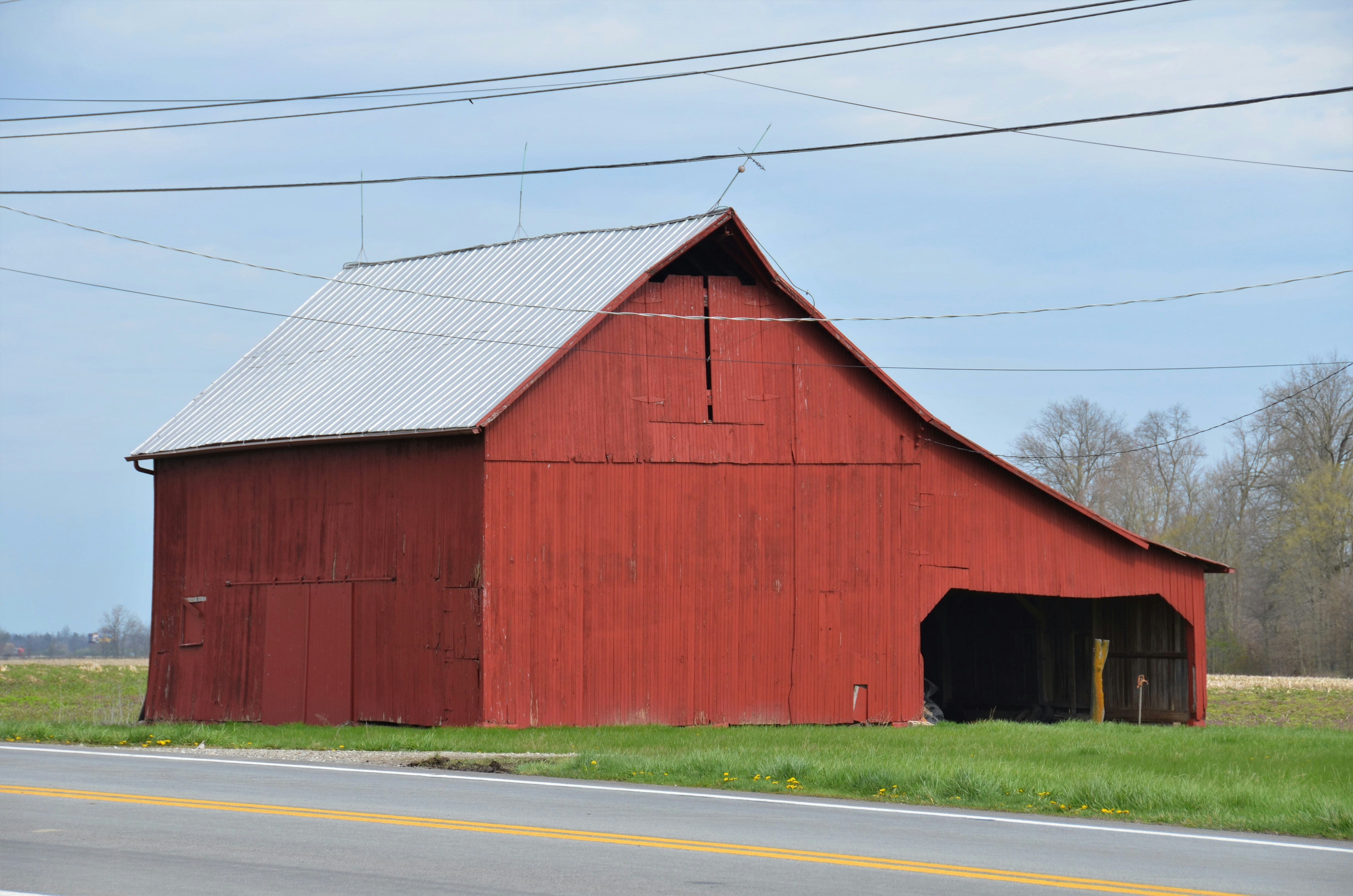 A red barn sitting on the side of a road photo – Free Nature Image on ...