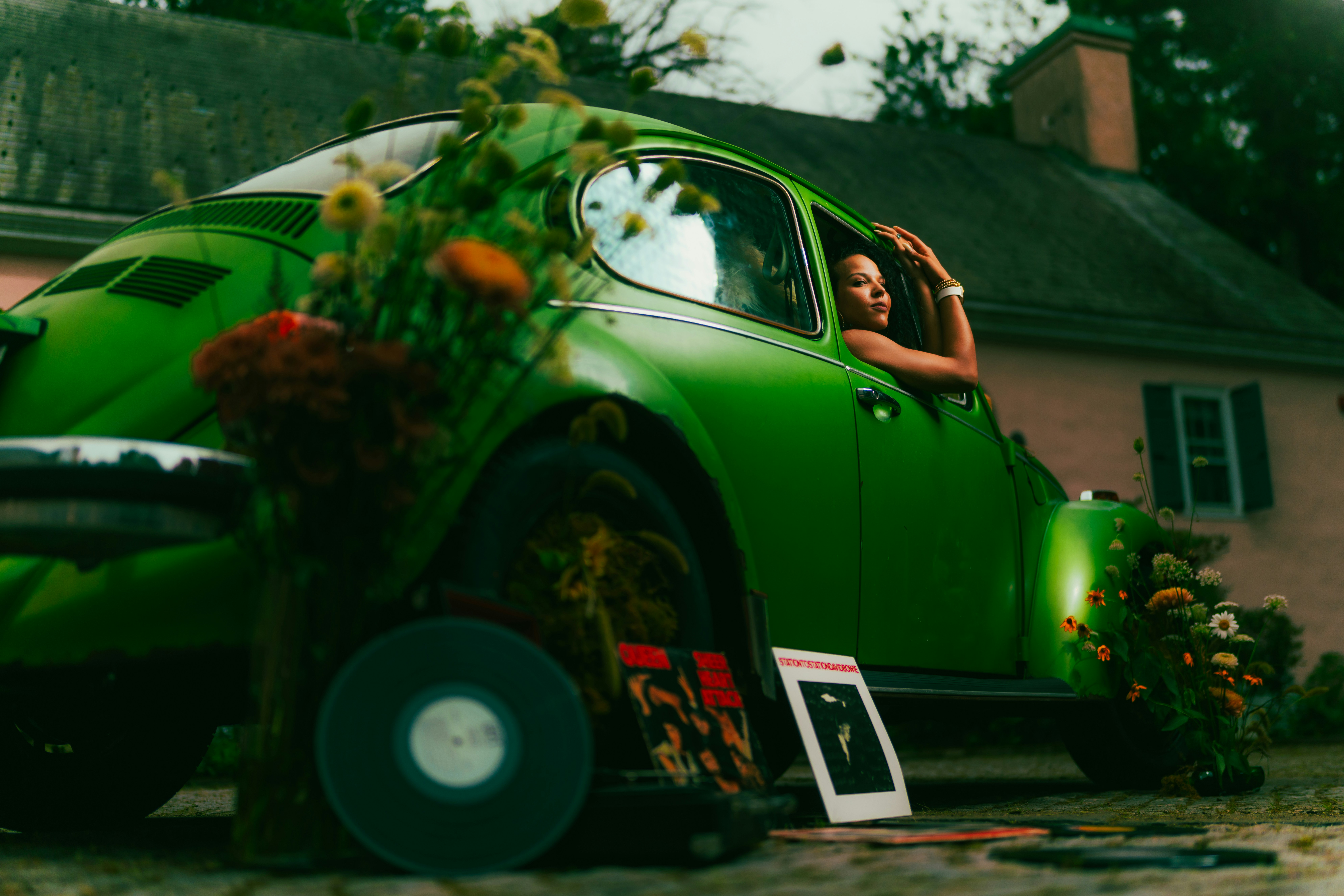 a woman leaning out of the window of a green car