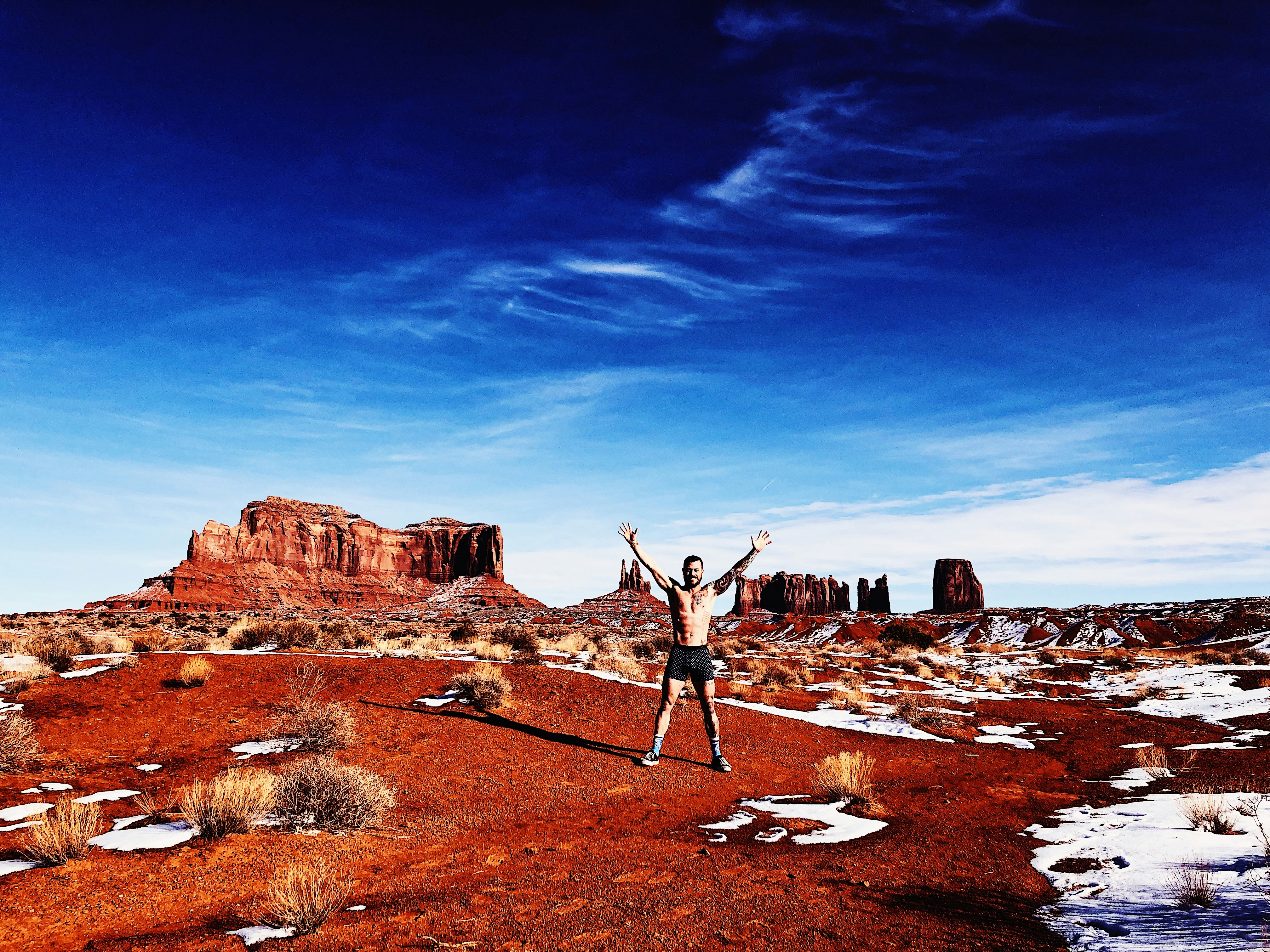 Joyful Stance on the Painted Desert Under a Cerulean Sky