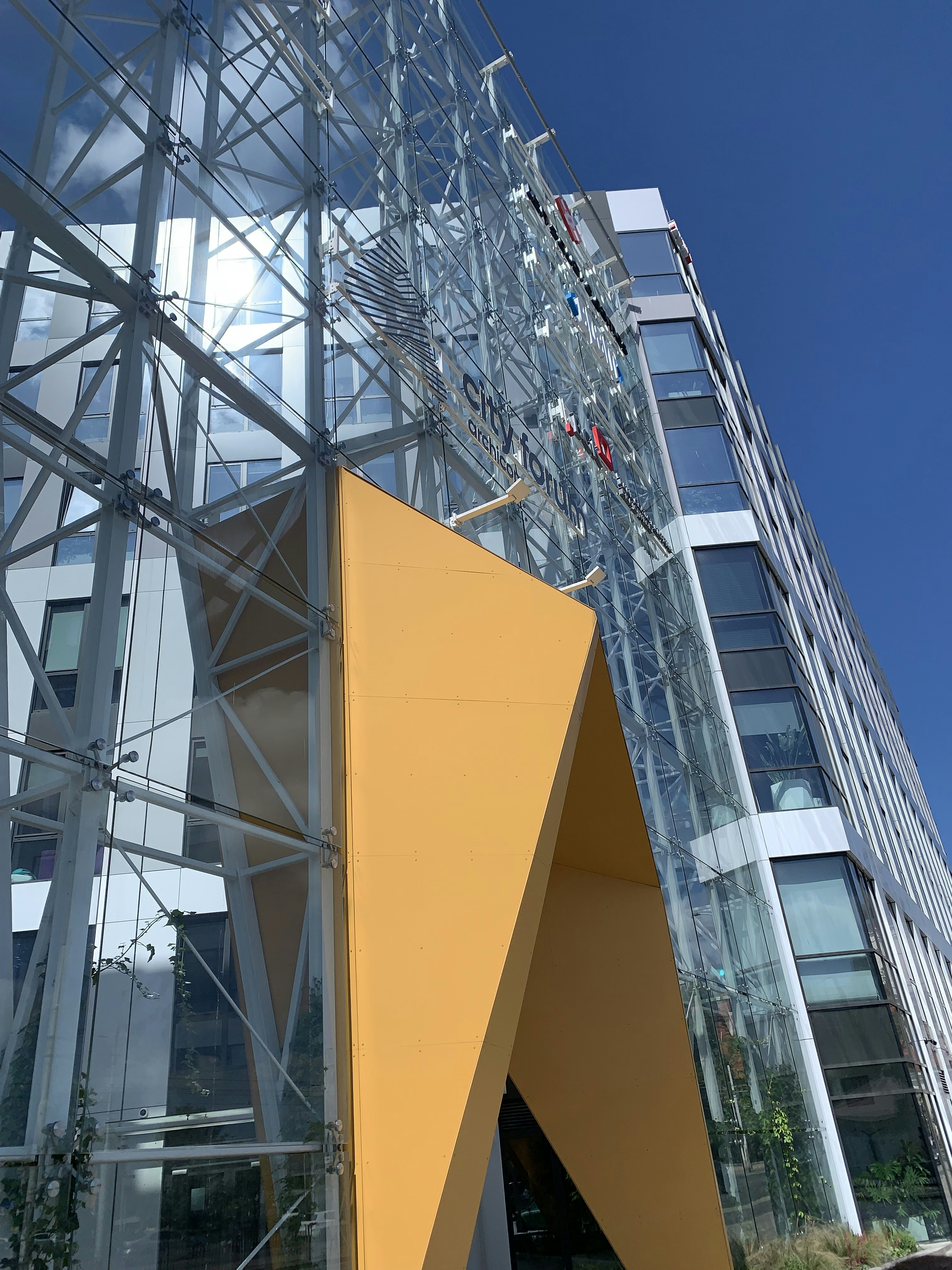 A tall building with a yellow triangle on top of it photo – Free Orange ...