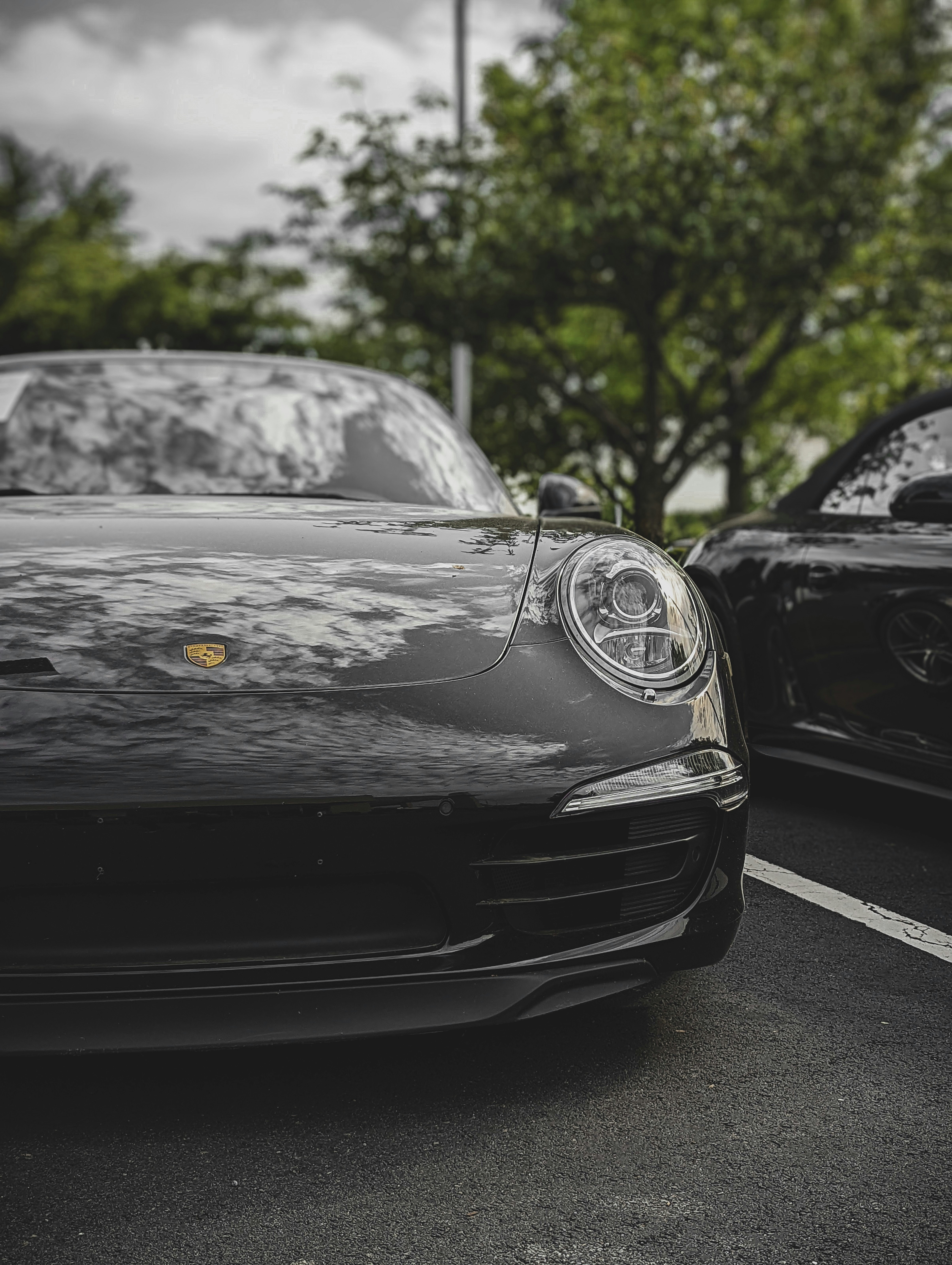 A Porsche reflects the cloudy sky