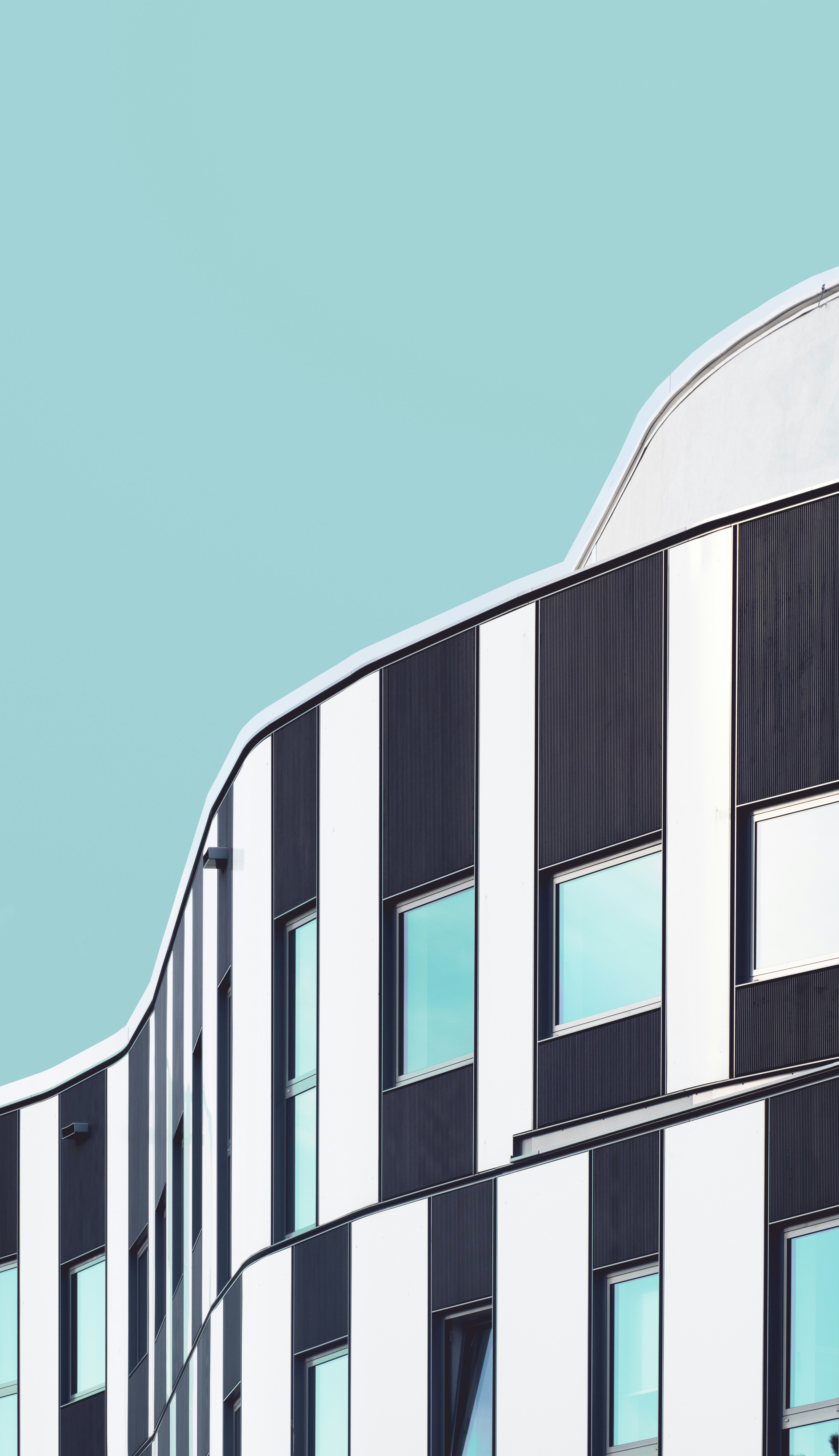 Curvilinear Facade: Striped Geometry Meets a Mint Sky