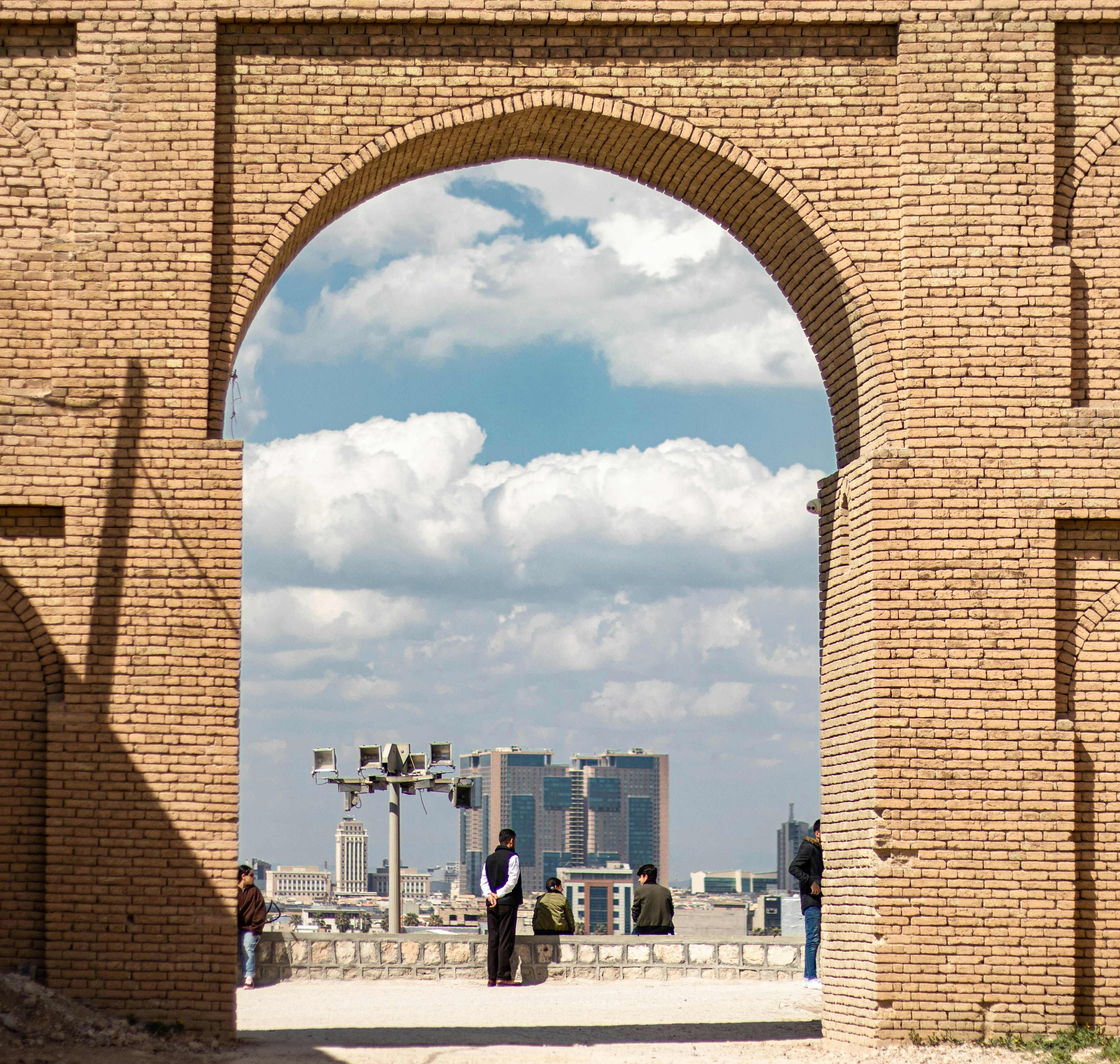A couple of people that are standing under an arch photo – Free Person ...