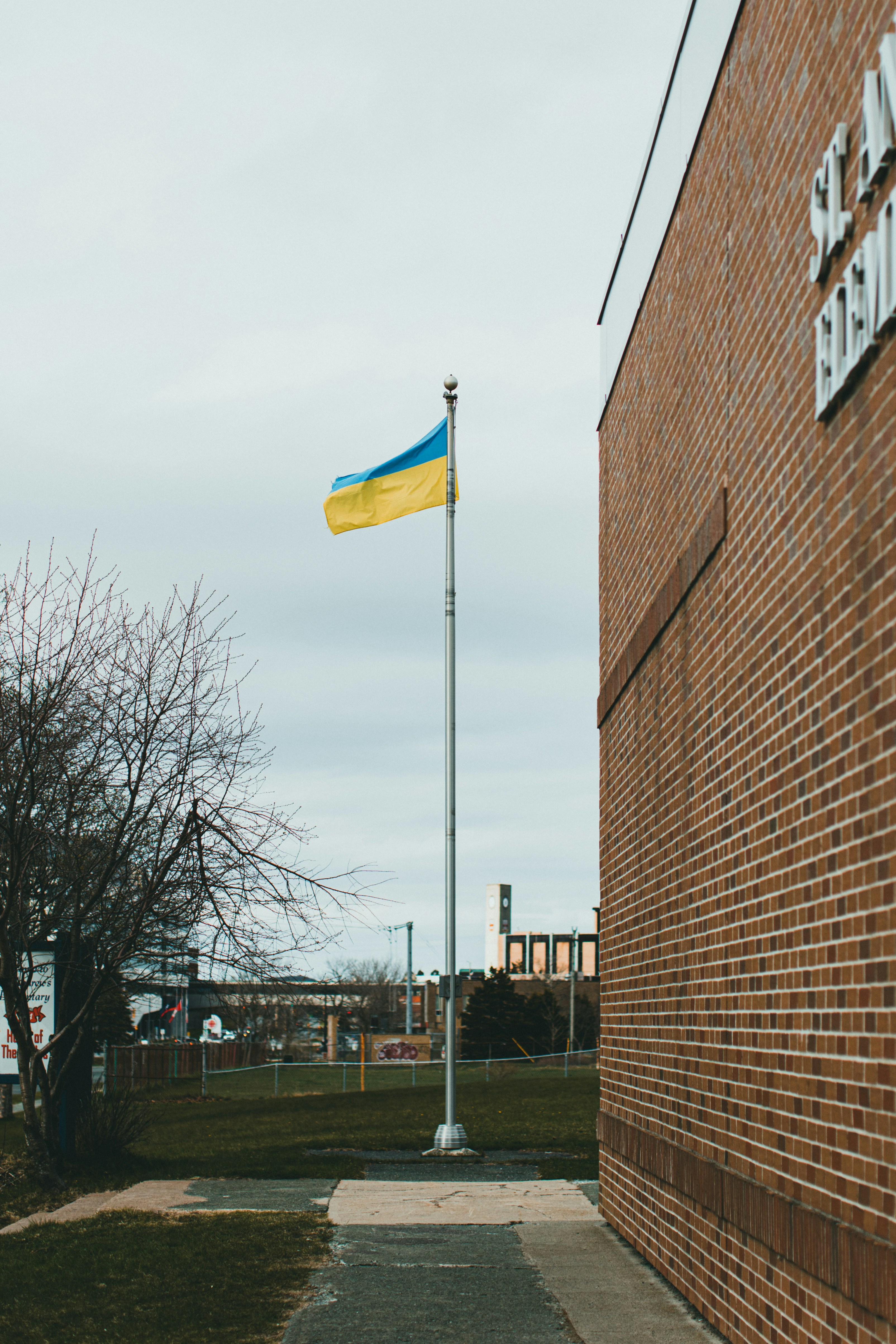 a flag on a pole next to a brick building