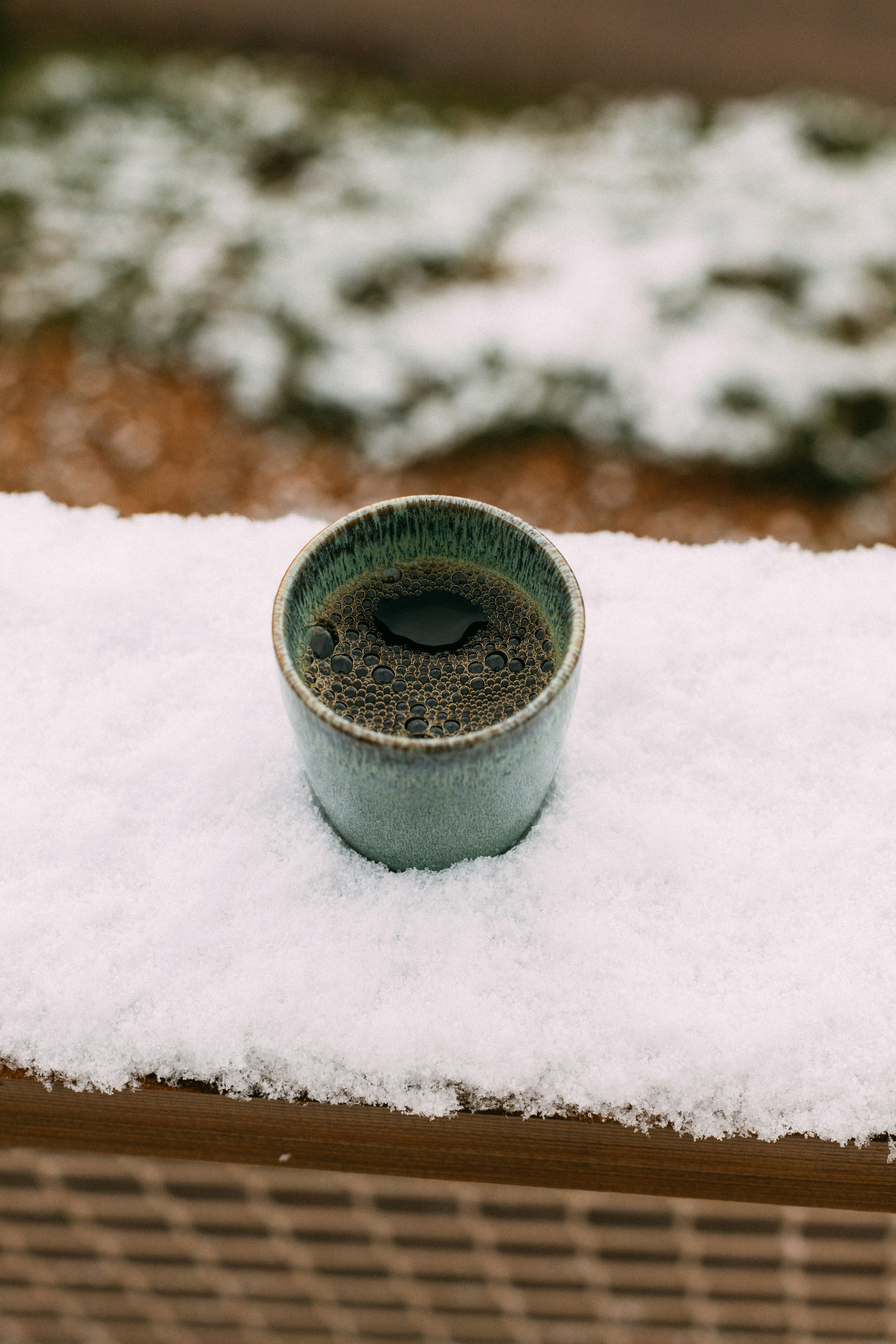 Teal Ceramic Cup on Snow: A Quiet Winter Moment on the Railing