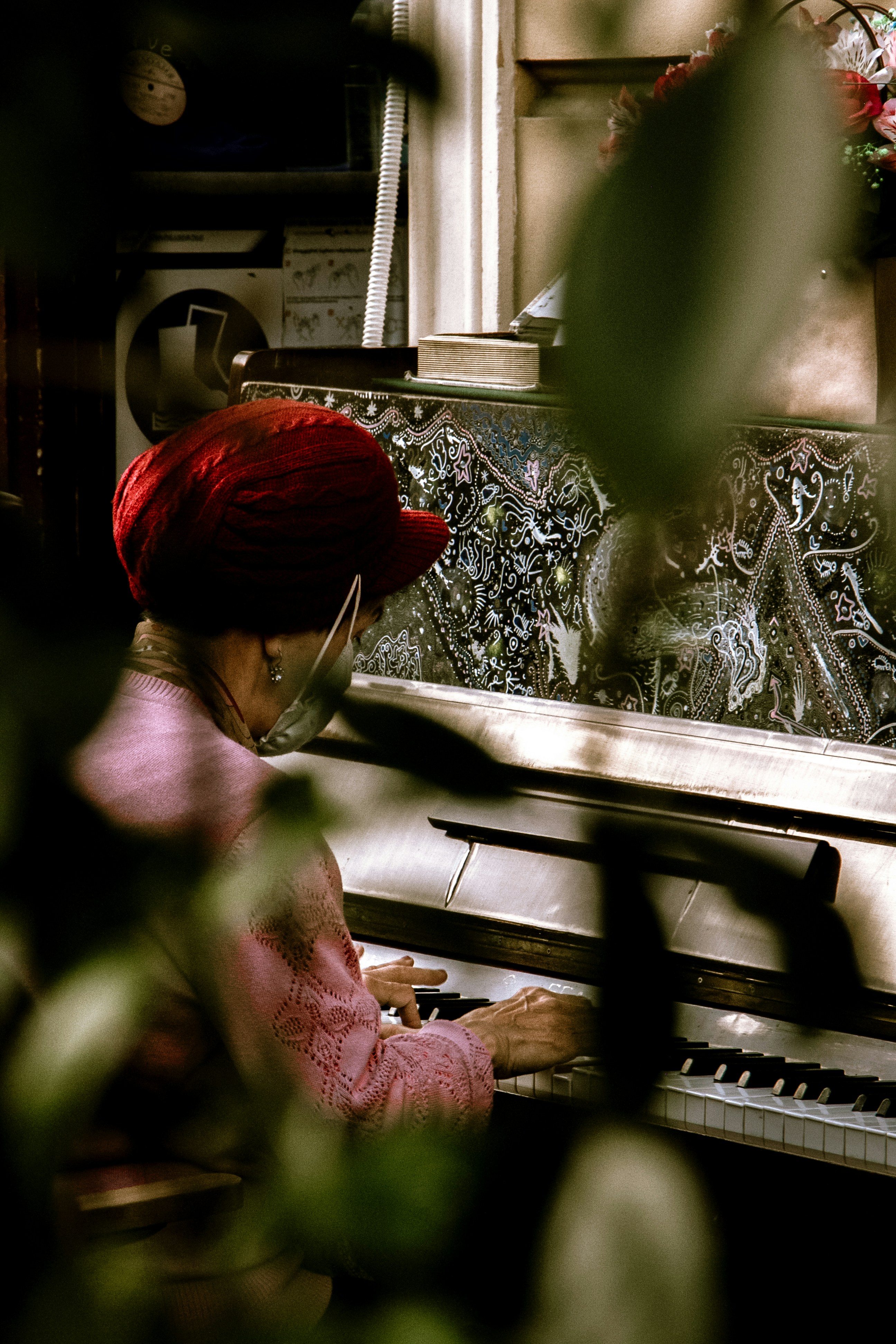 Red-Hatted Pianist in a Storefront Window, Fingers on the Keys