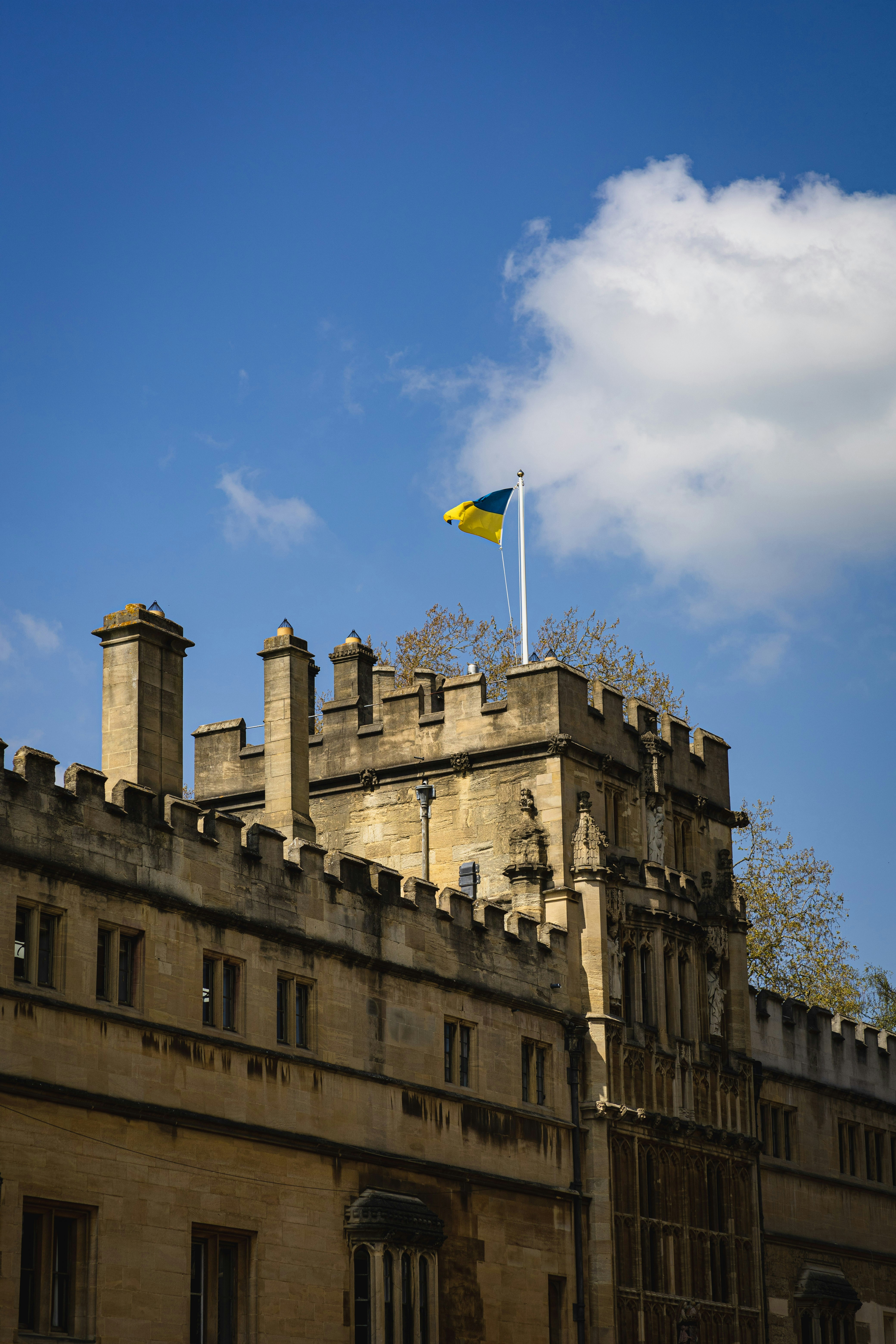 Flag atop the sunlit fortress against a cobalt sky