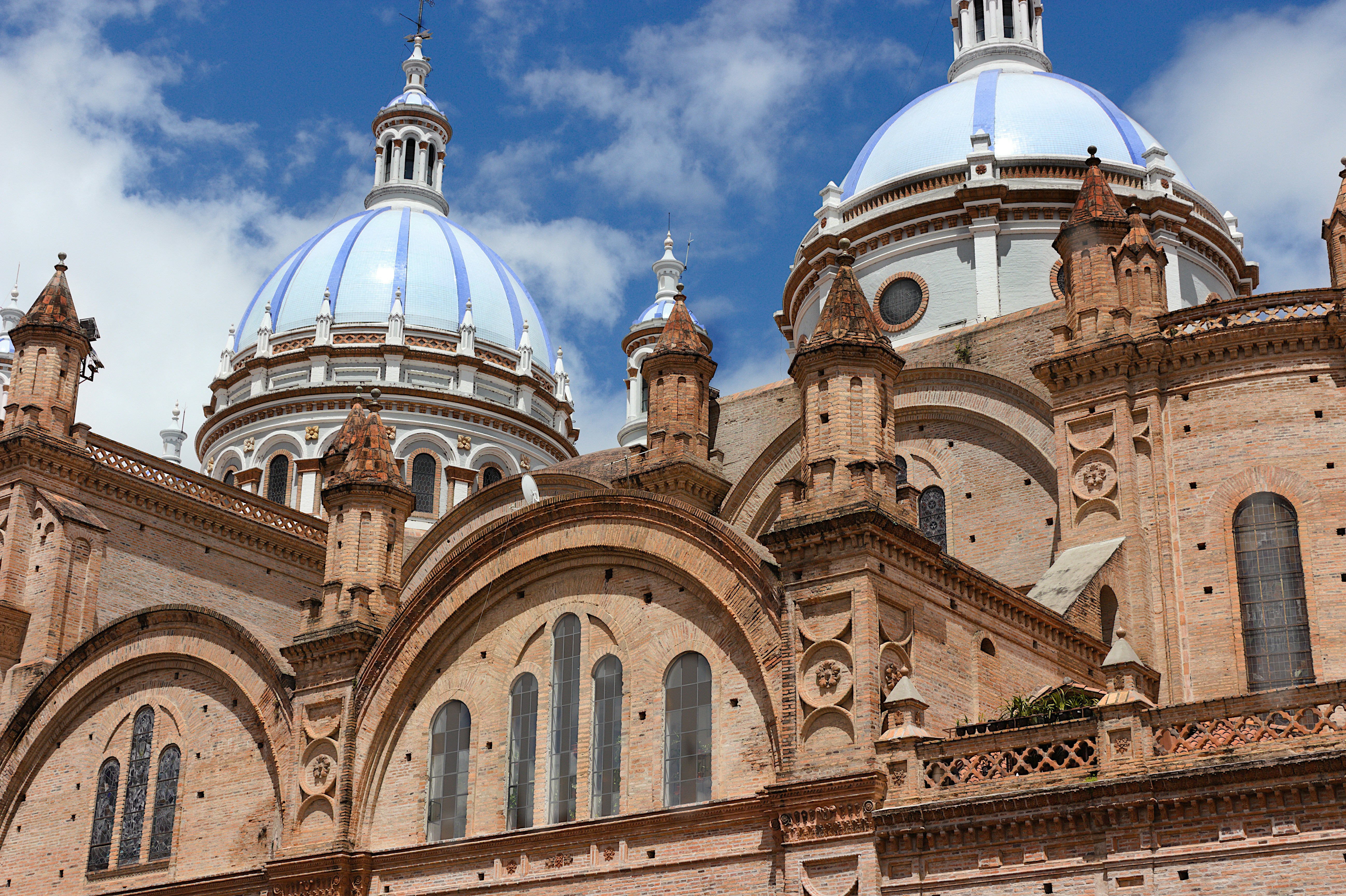 Ornate building facade with two prominent blue domes under a vibrant sky.