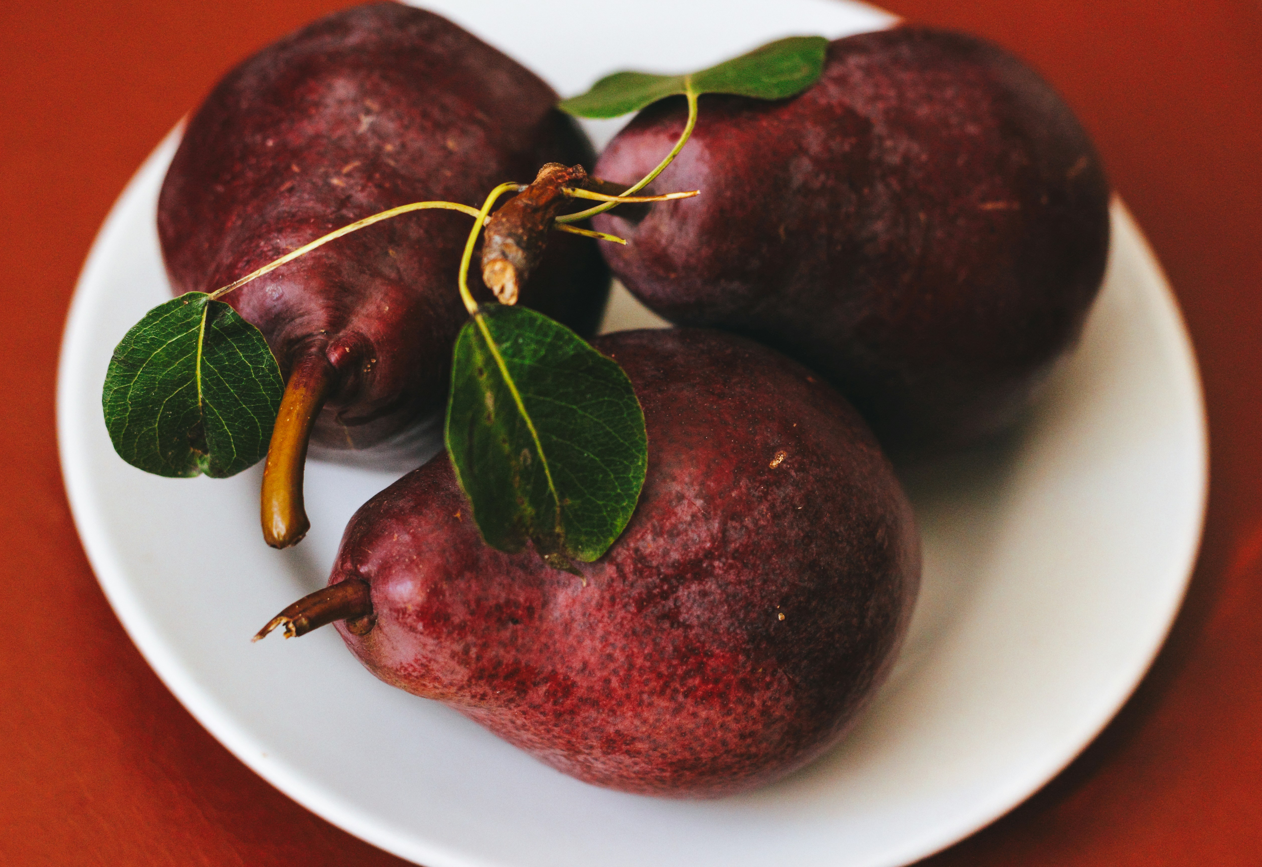 Plump Red Pears on a White Plate