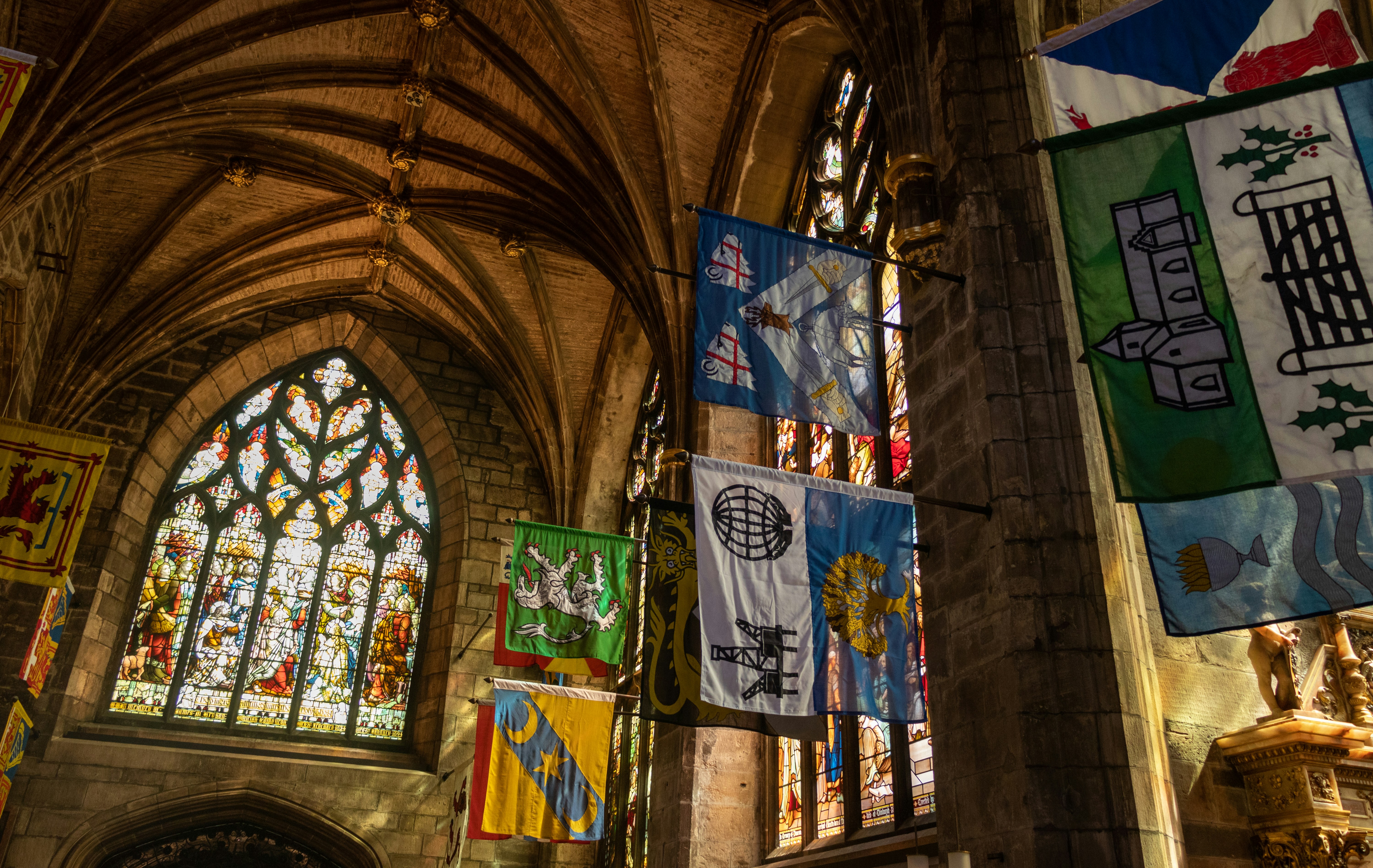 A cathedral with stained glass windows and banners hanging from the ...