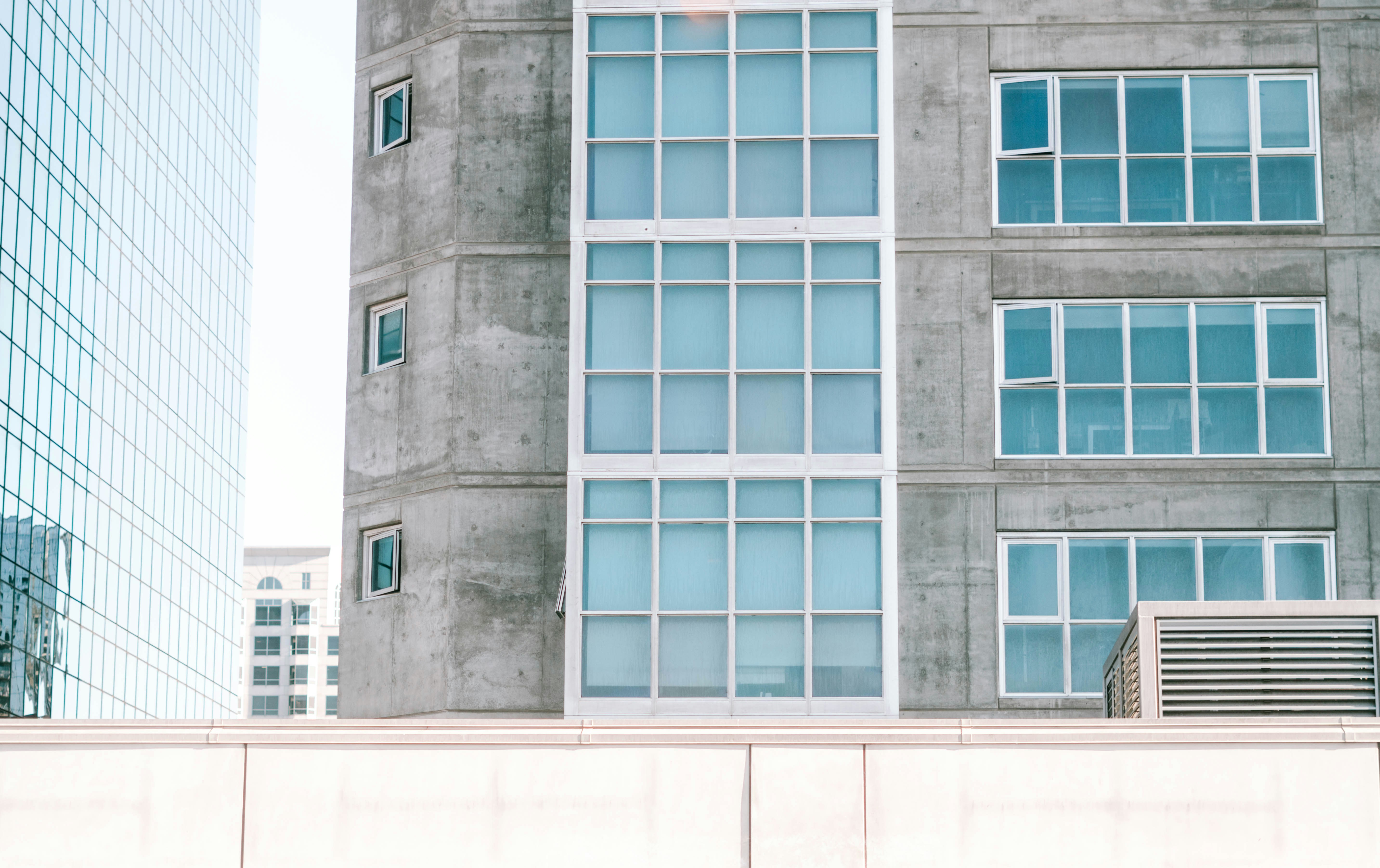 Grid of Glass and Concrete: A Central Window Facade Framed by Urban Giants