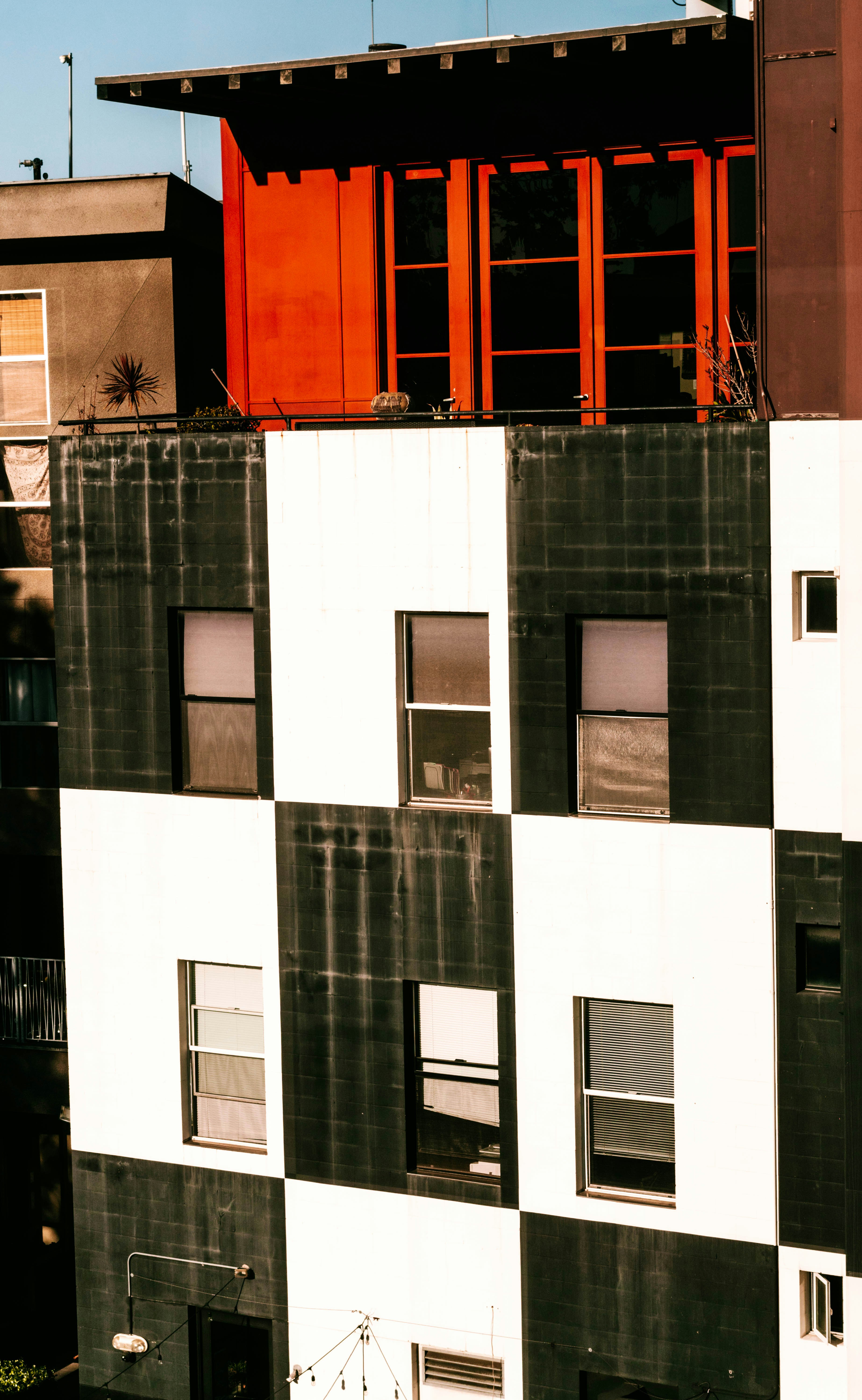 Checkerboard Facade: A Sunlit Urban Quilt of Windows and Color