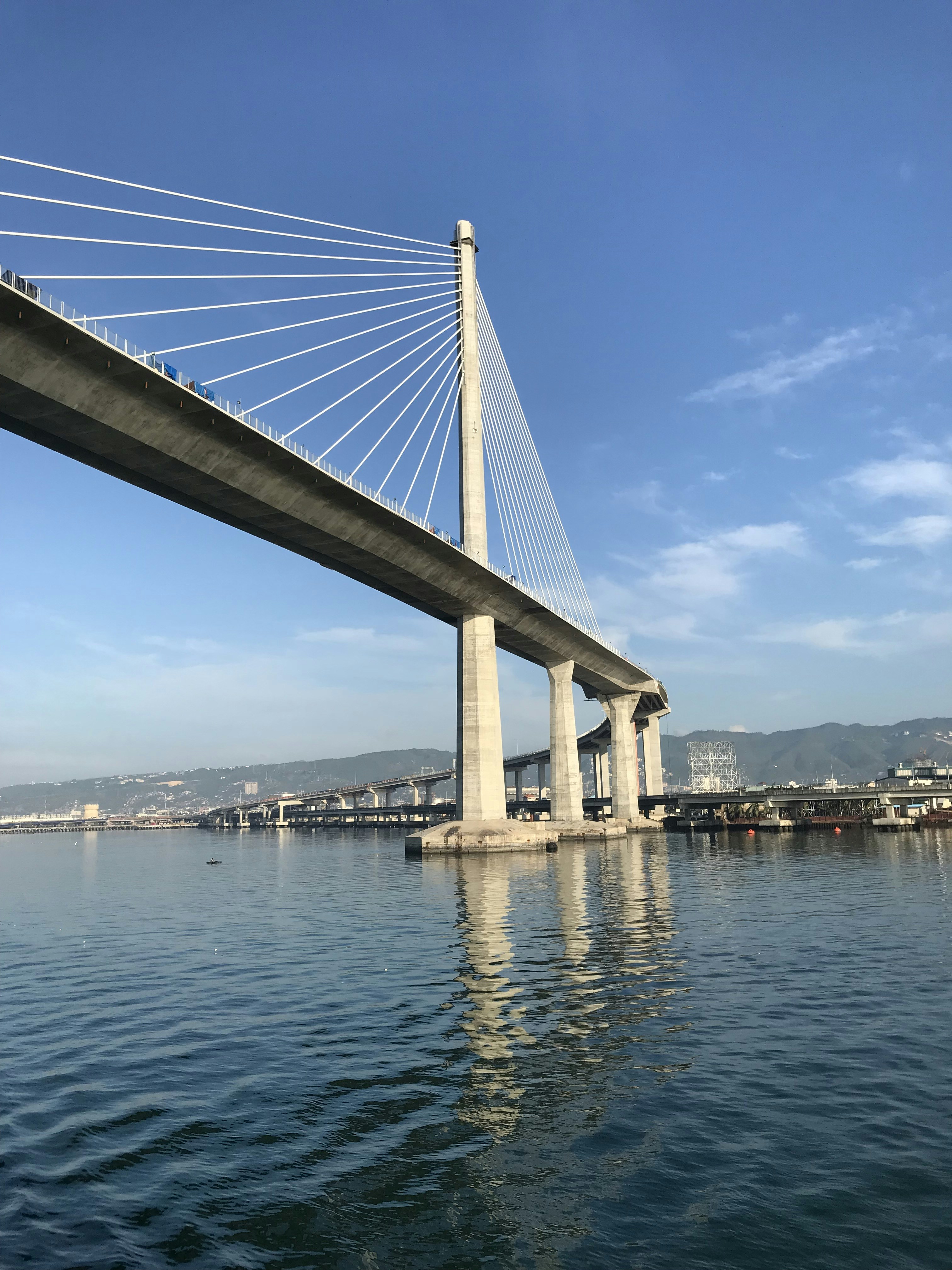 Azure Trusses Over Calm Harbor: A Cable-Stayed Bridge Framed by Sky