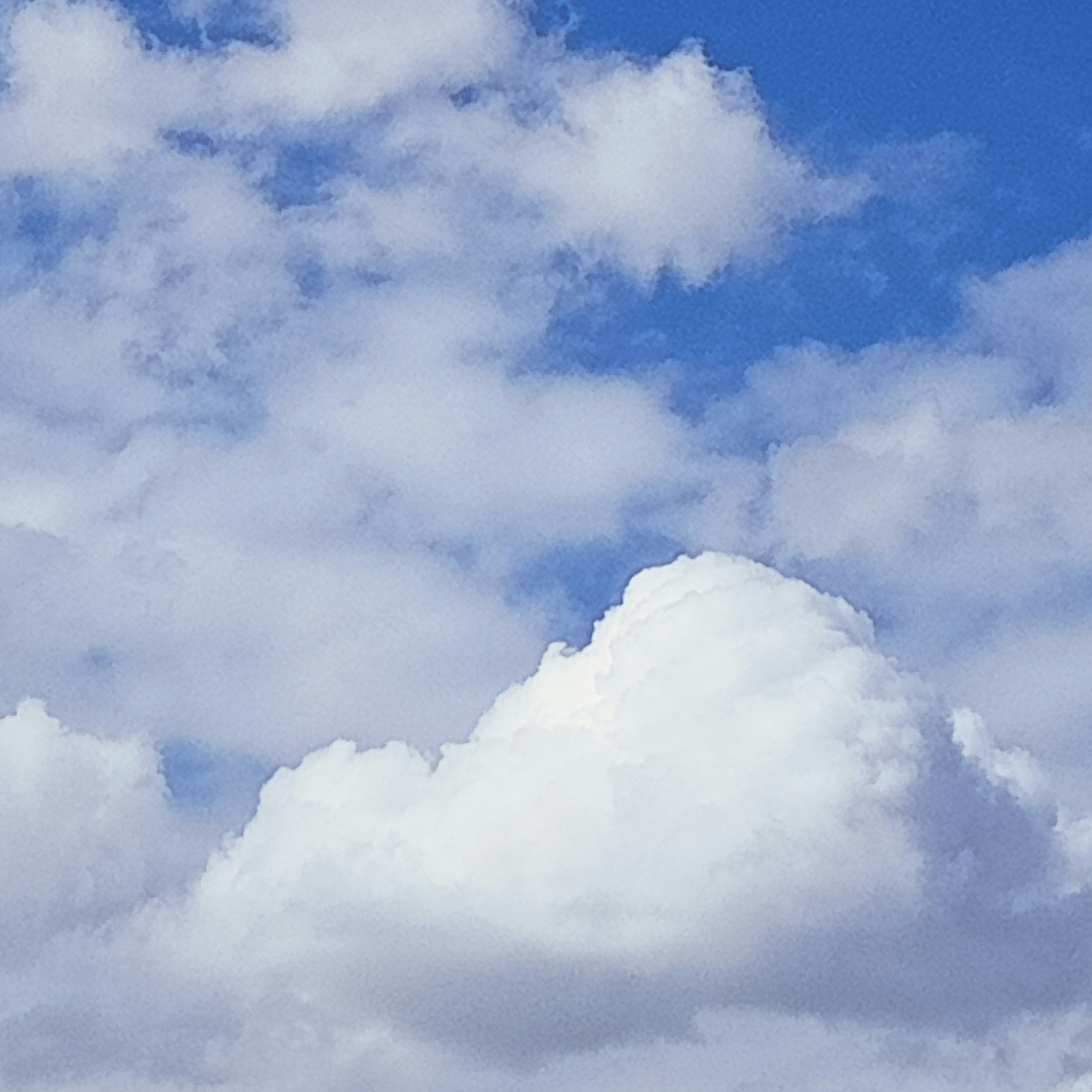 Fluffy white clouds drifting against a vibrant blue sky, conveying a sense of tranquility.