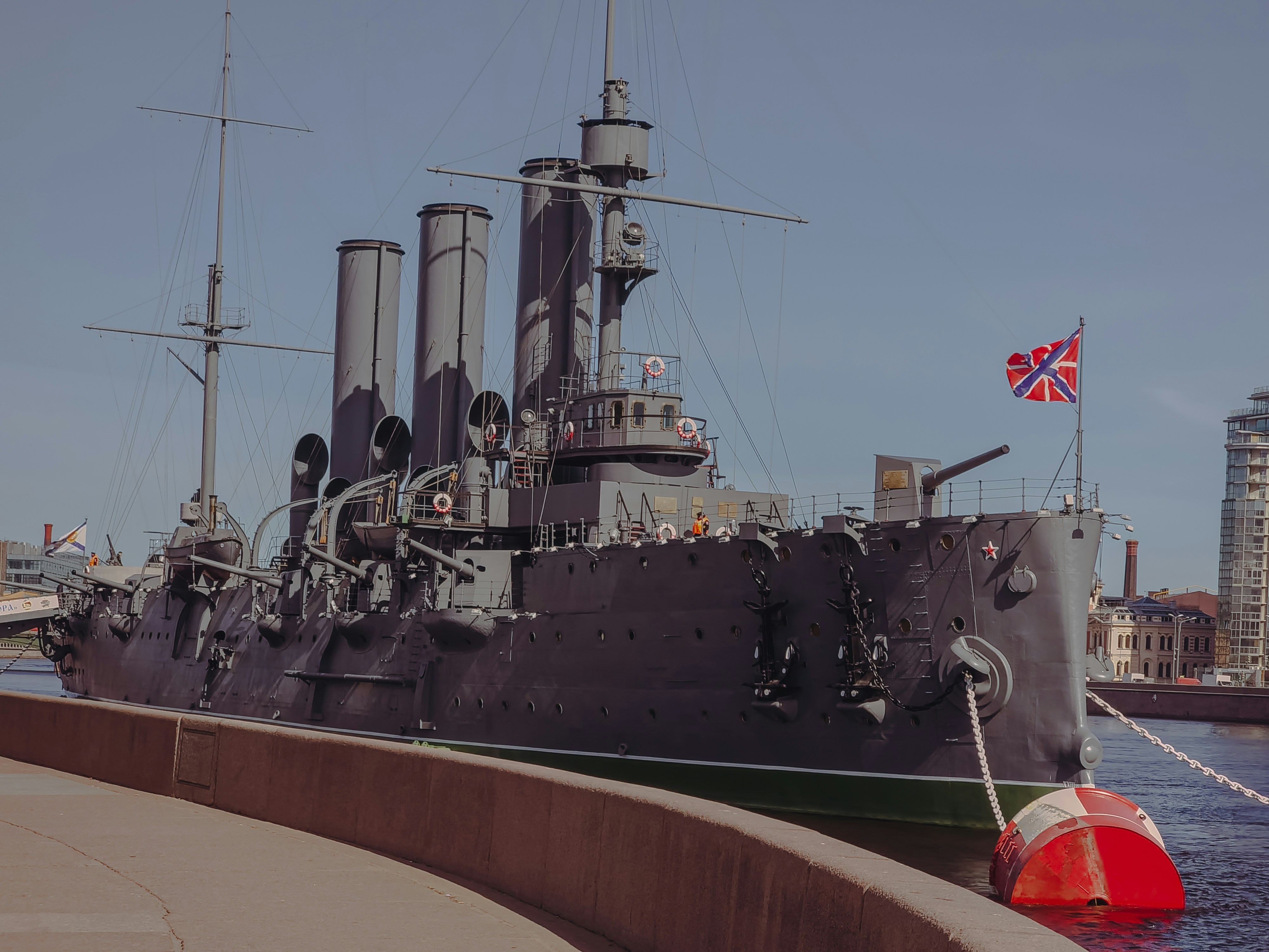 a large battleship sitting in the water next to a dock