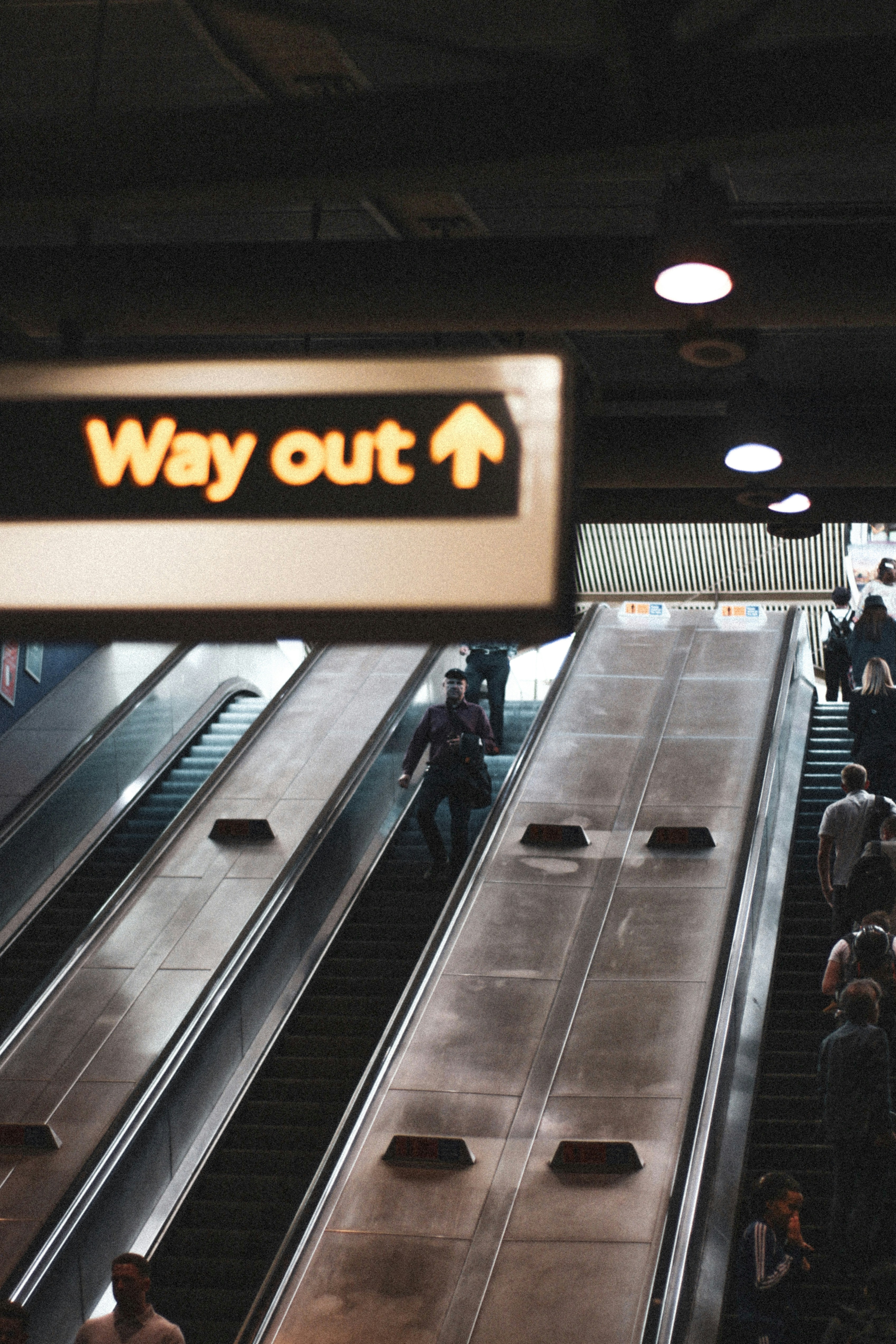 Way Out Glow Over Busy Escalators in a Subterranean Hub