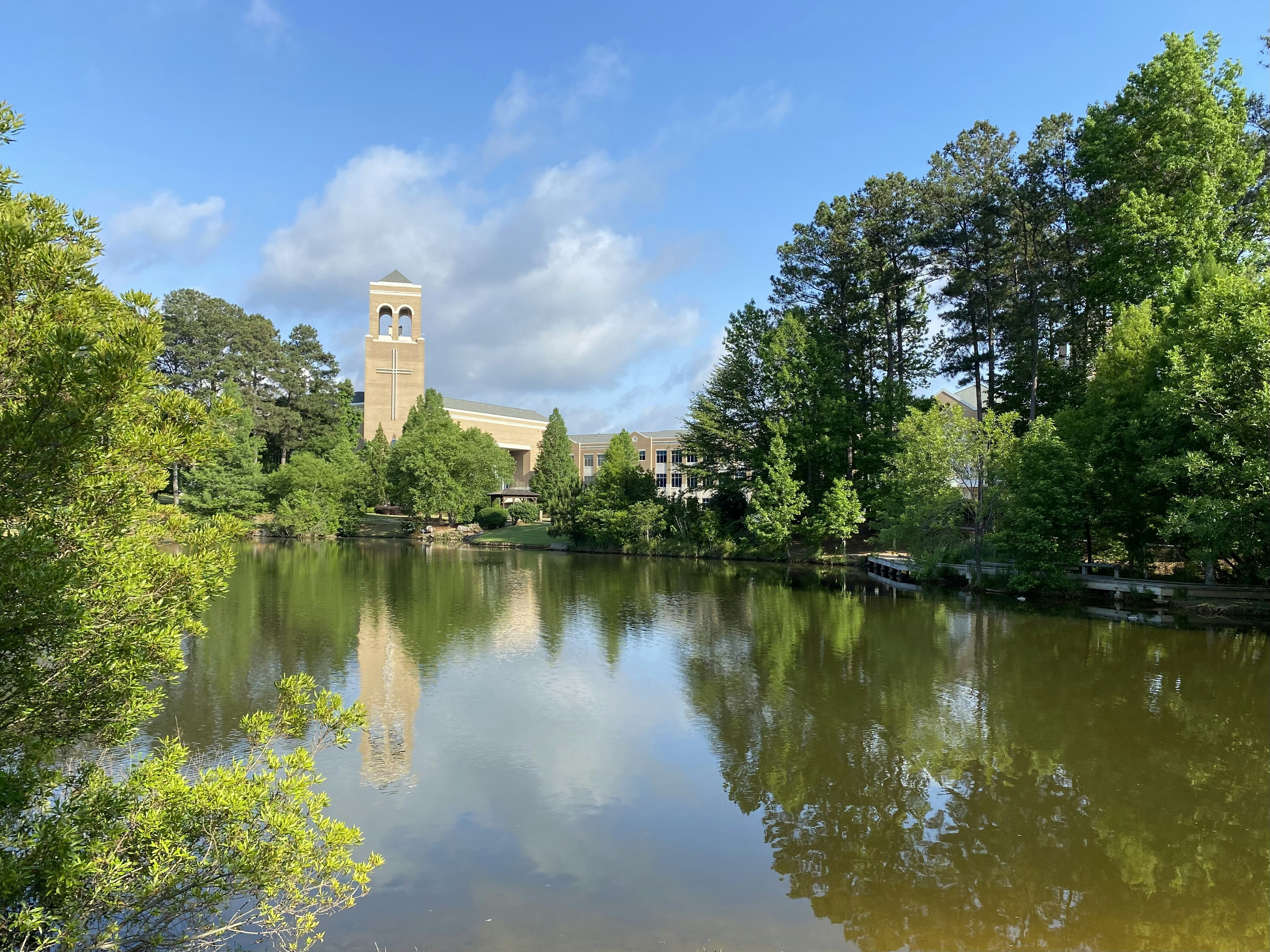 Bell Tower Reflections Over a Sunlit Campus Lake
