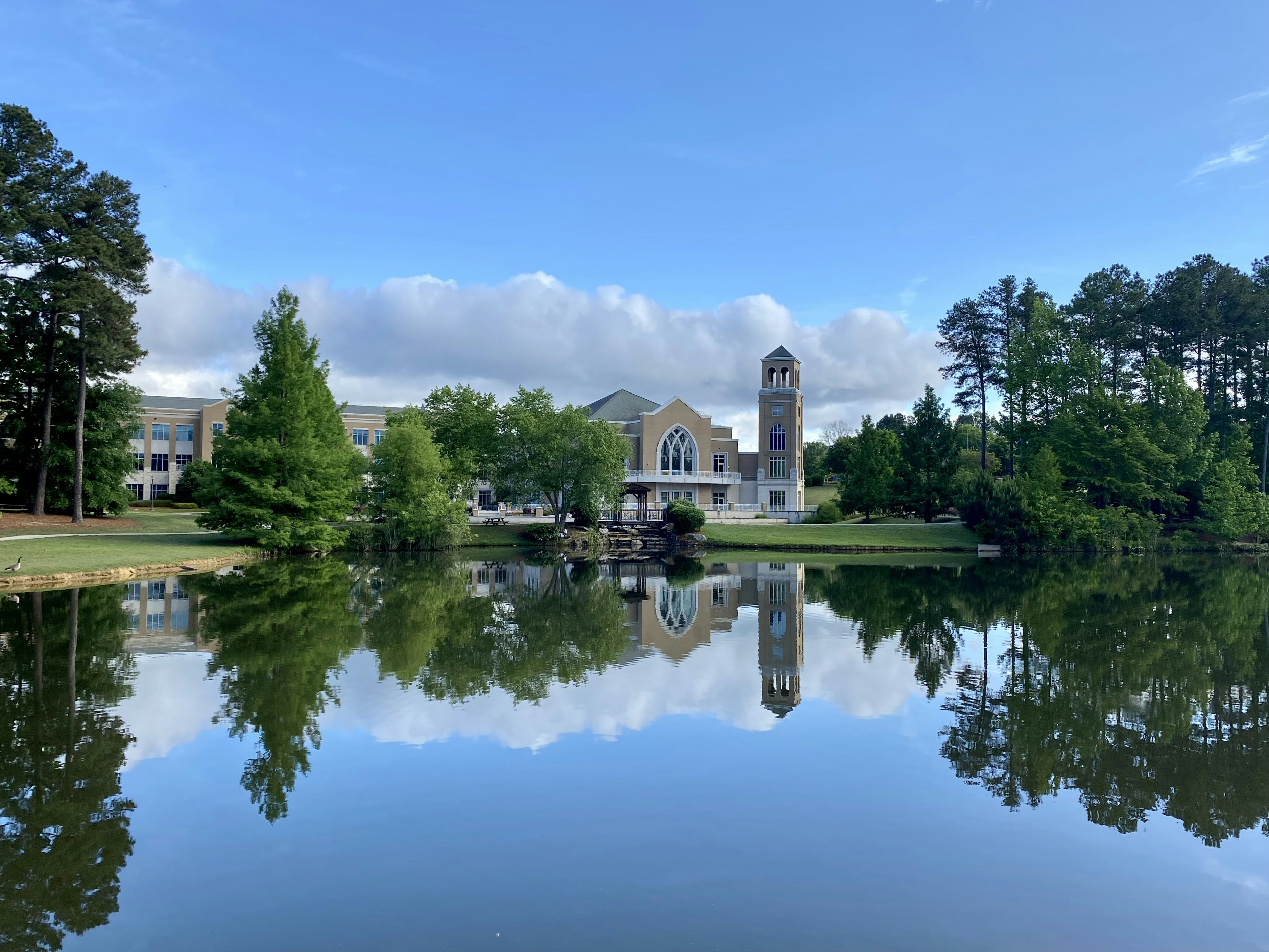 Clock Tower Campus Centerpiece Reflected Across a Calm Lake