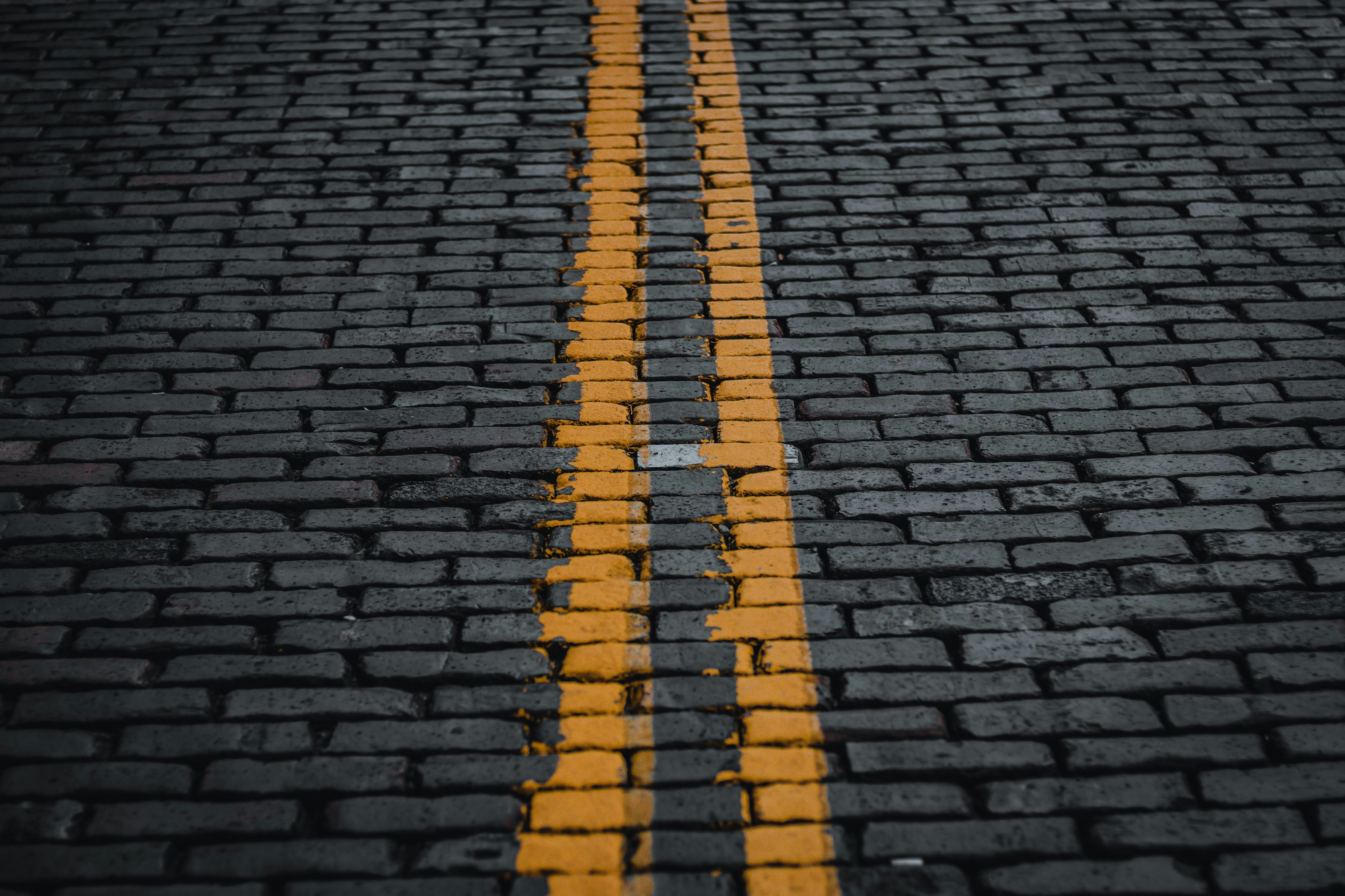 Vanishing Yellow Lines Across a Cobblestone Street