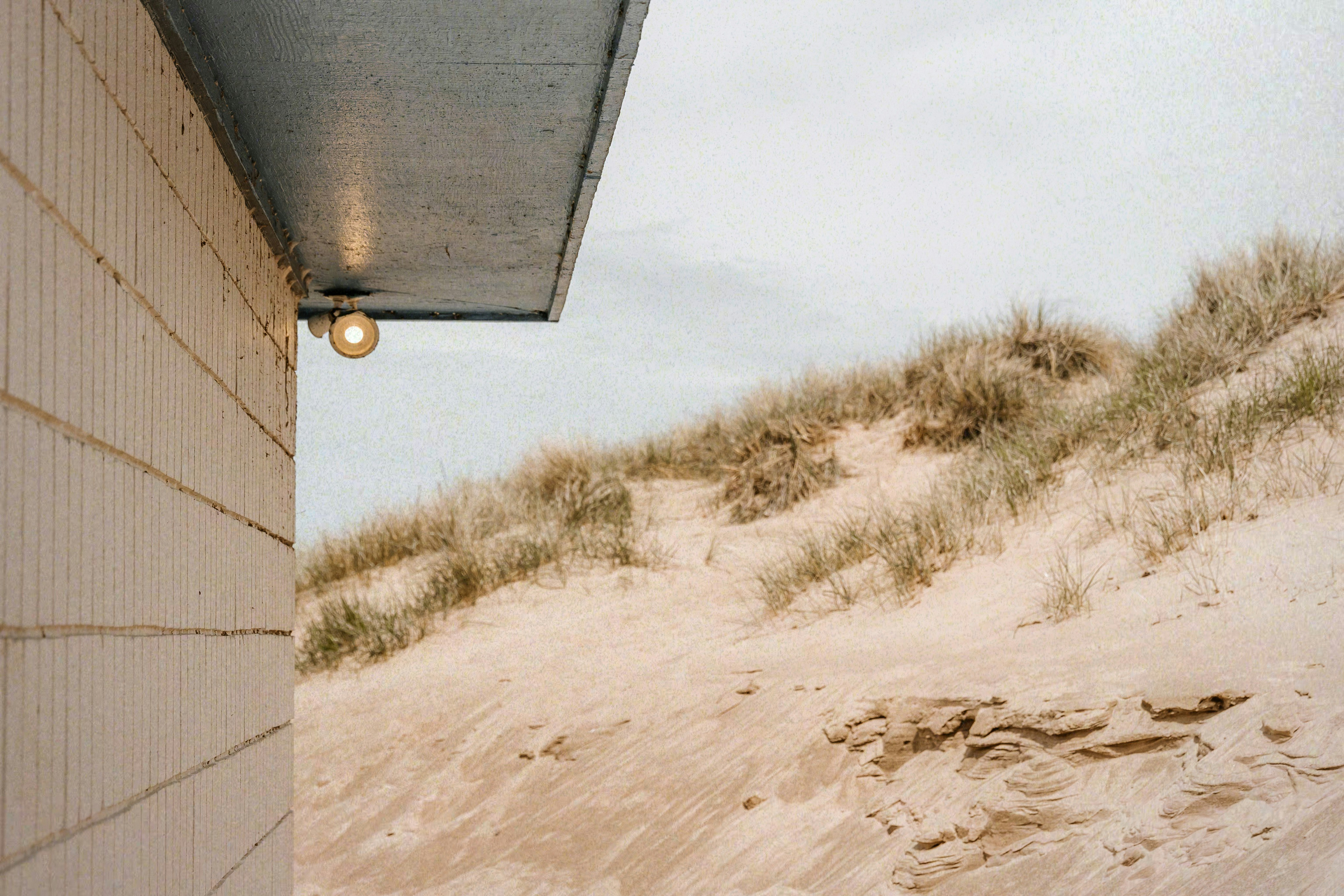 Old beach house next to sand dunes