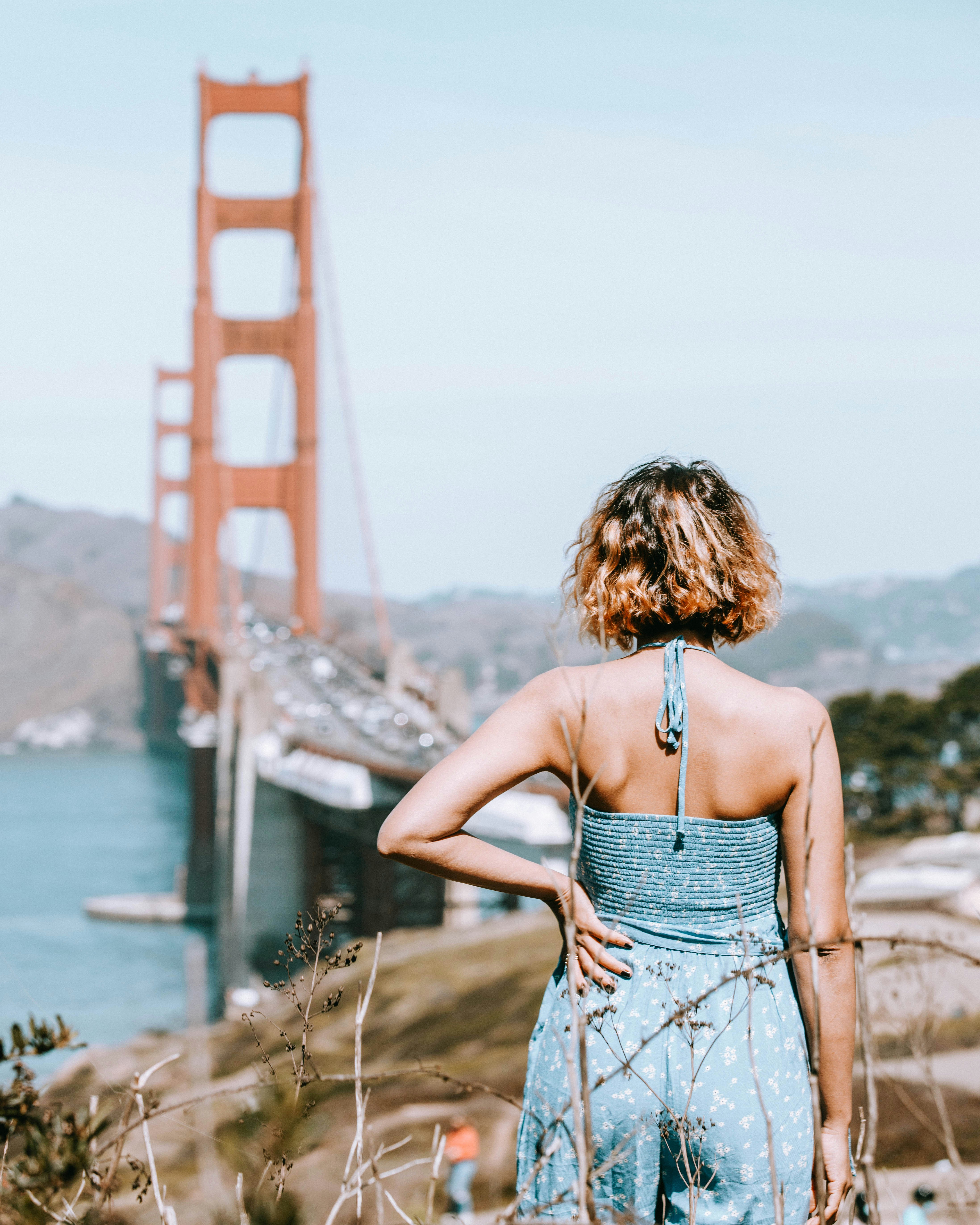 a woman standing in front of the golden gate bridge