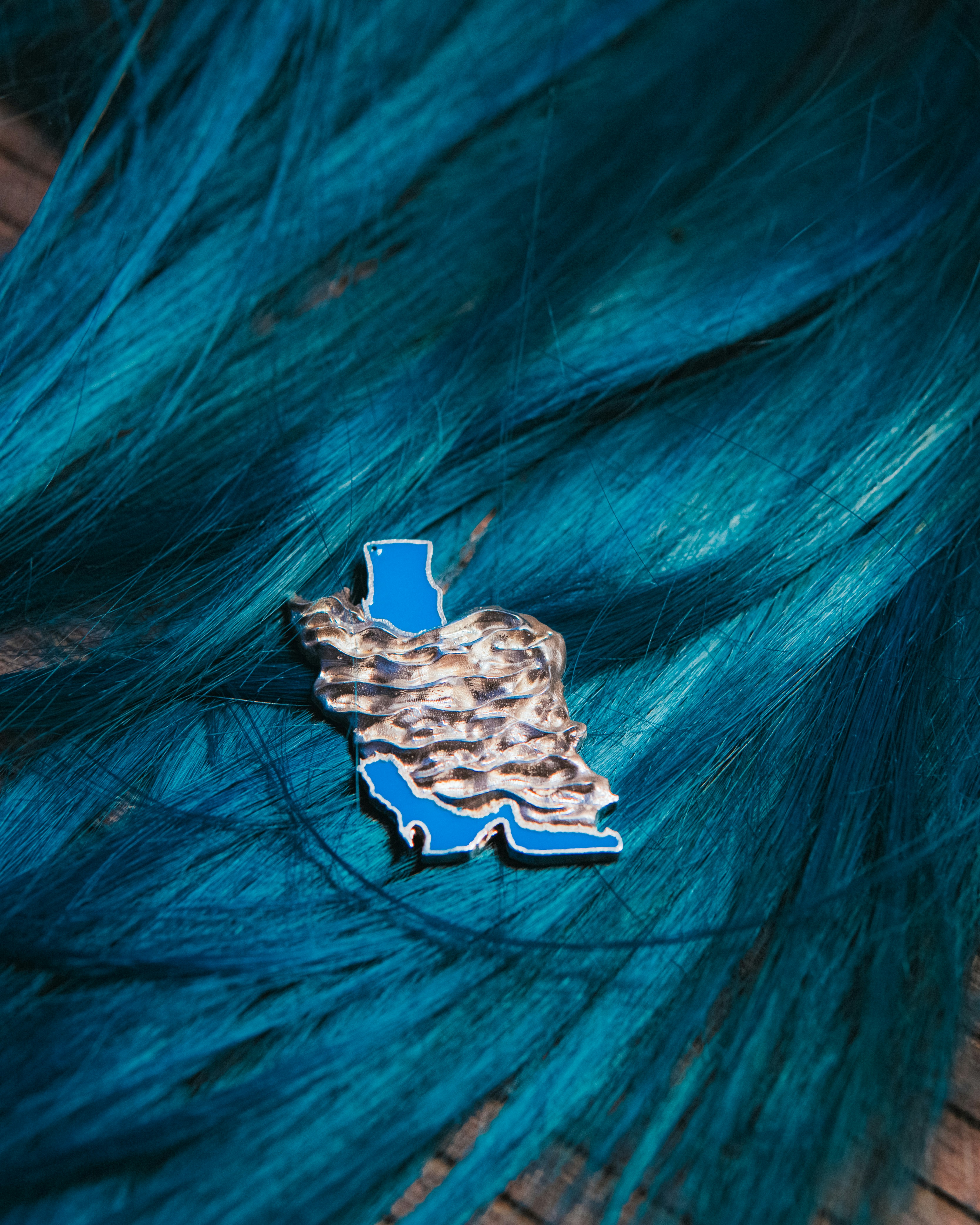 Azure Texas Enamel Pin Nestled in Turquoise Hair Strands