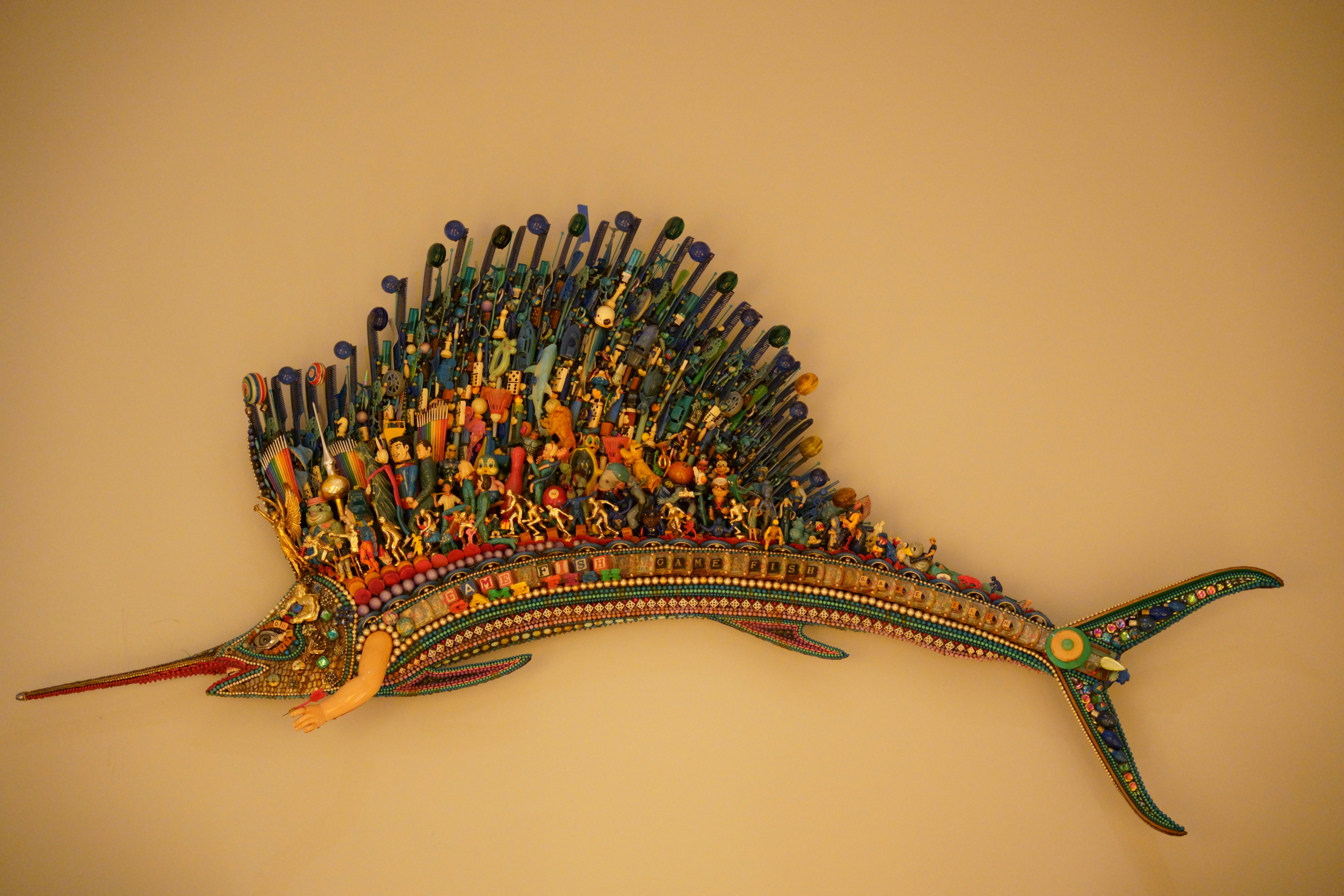 The Parade Fish: A Hand-Carved Creature Dusted with Tiny Figures Along Its Dorsal Crest