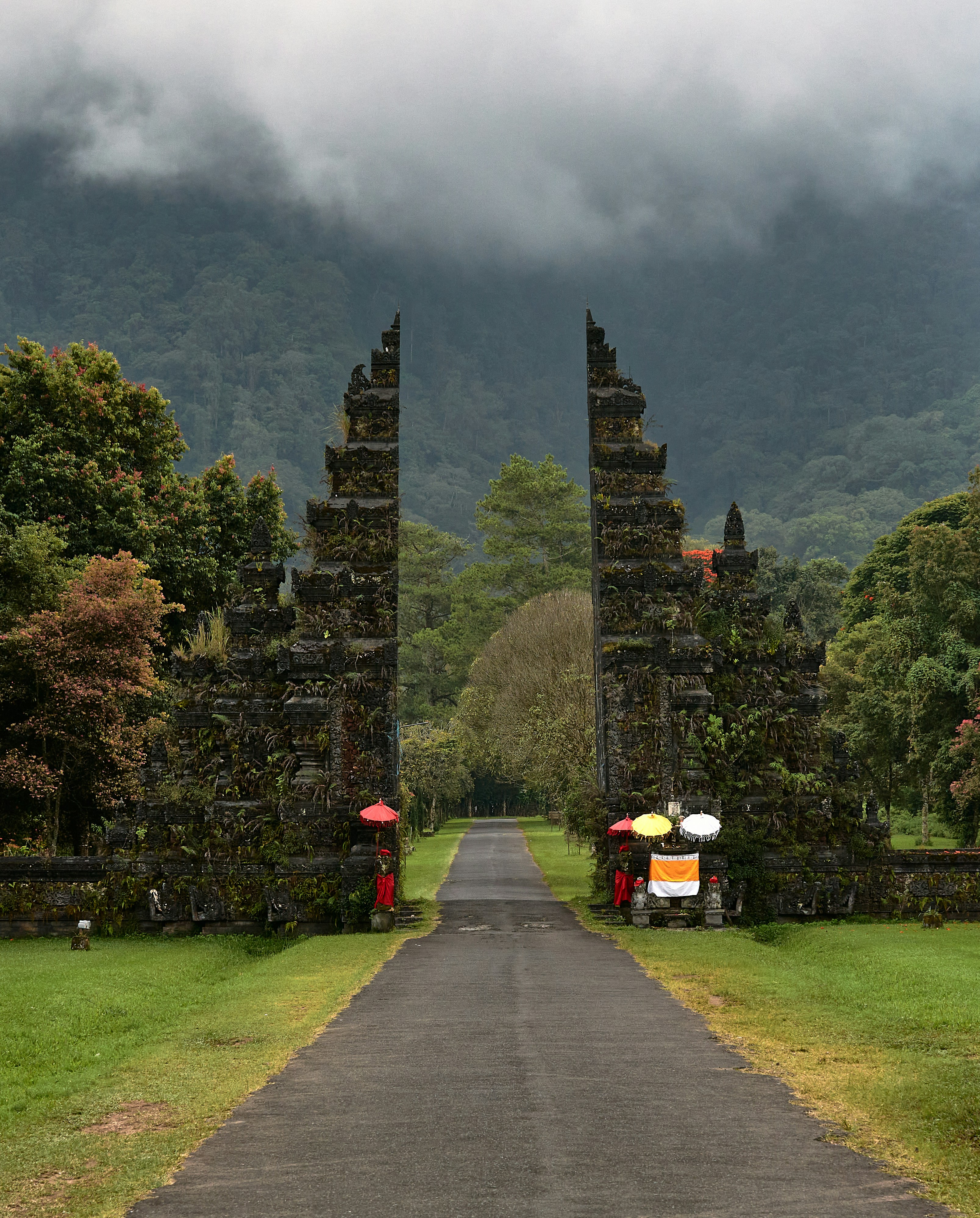 Handara Gate | a couple of people with umbrellas walking down a road