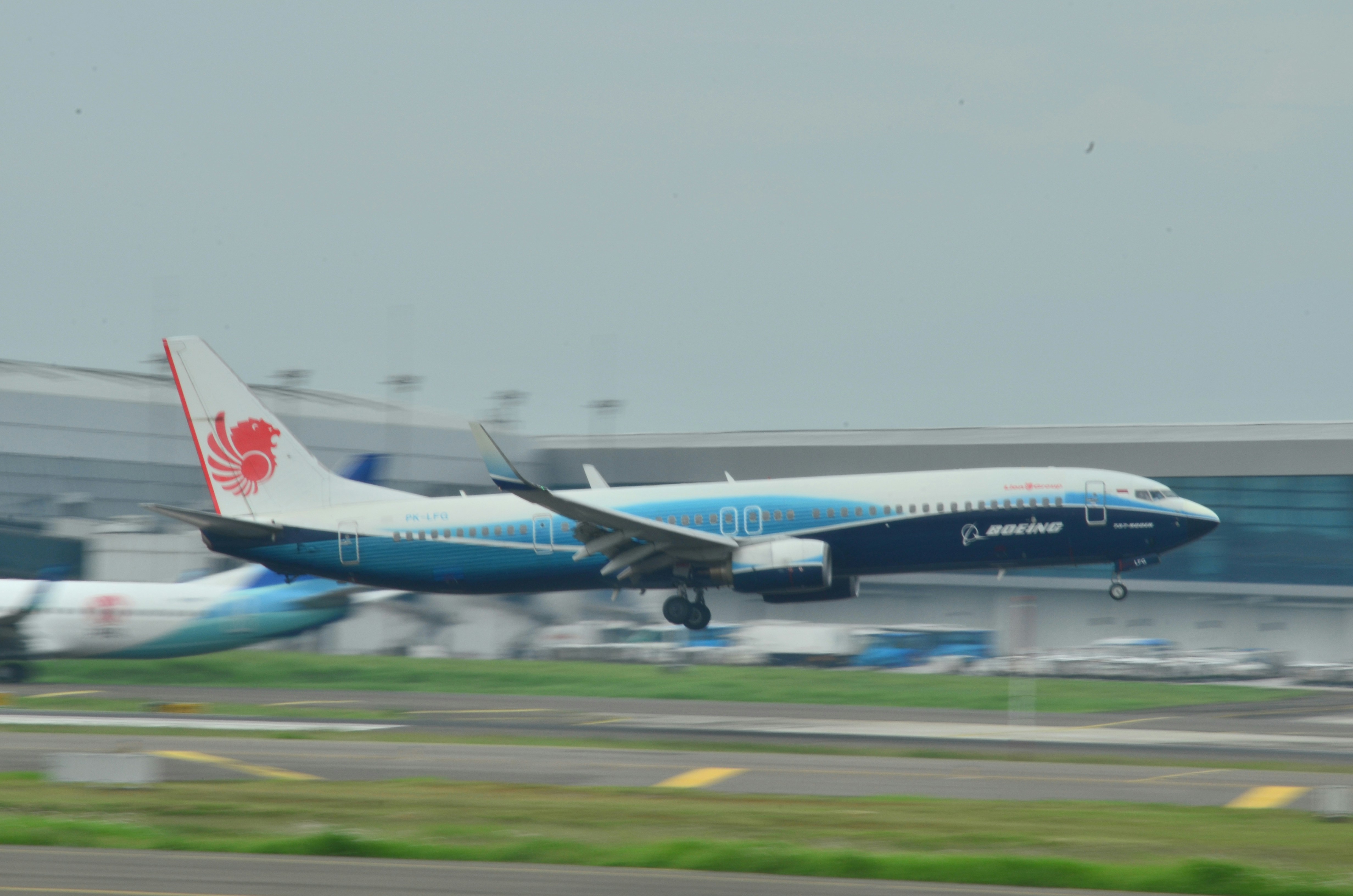 Commercial jet taking off from the runway, showcasing its sleek design and vibrant livery against a cloudy sky.