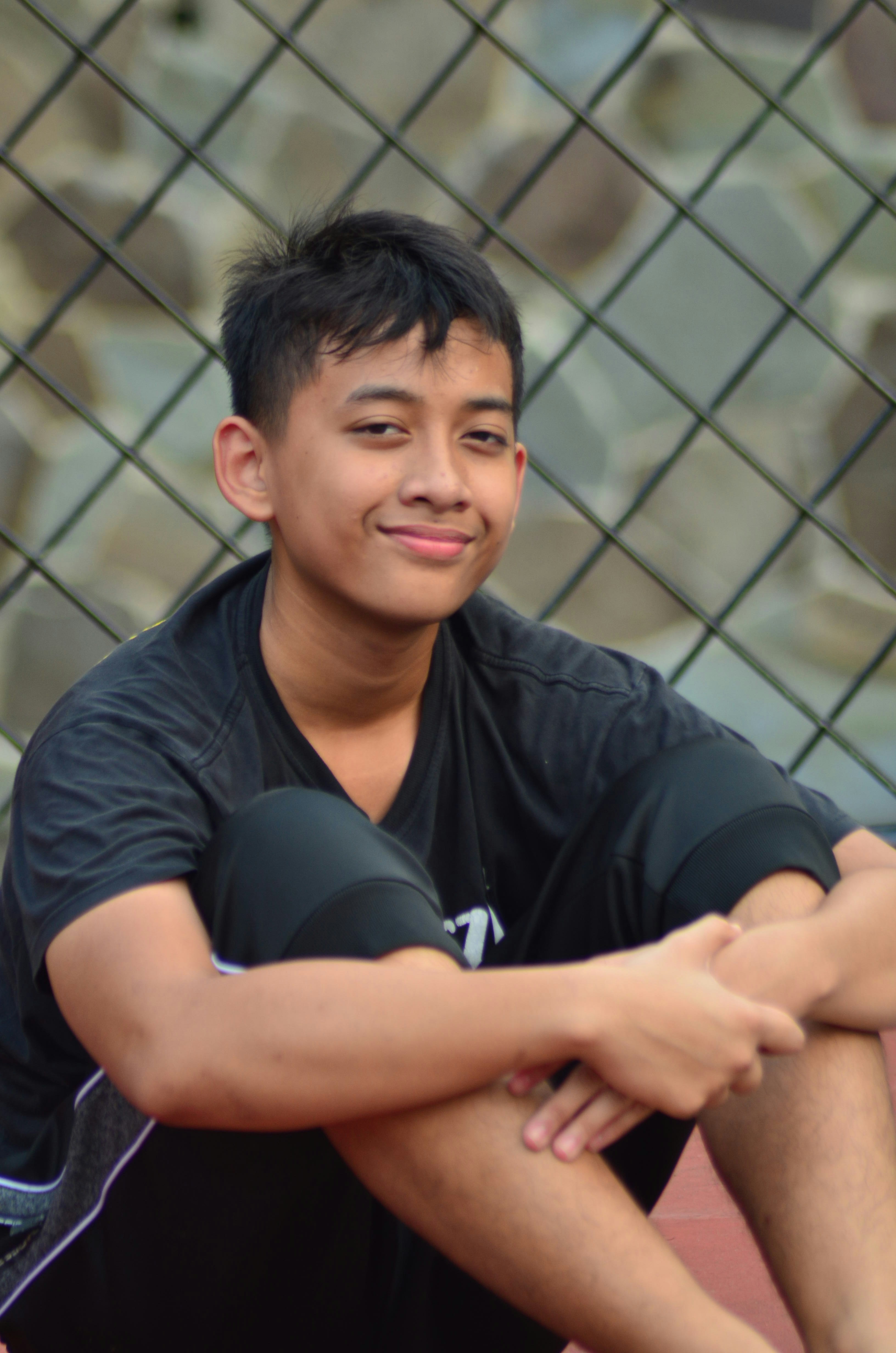 A man sitting on the ground with his arms crossed photo – Free Grey ...